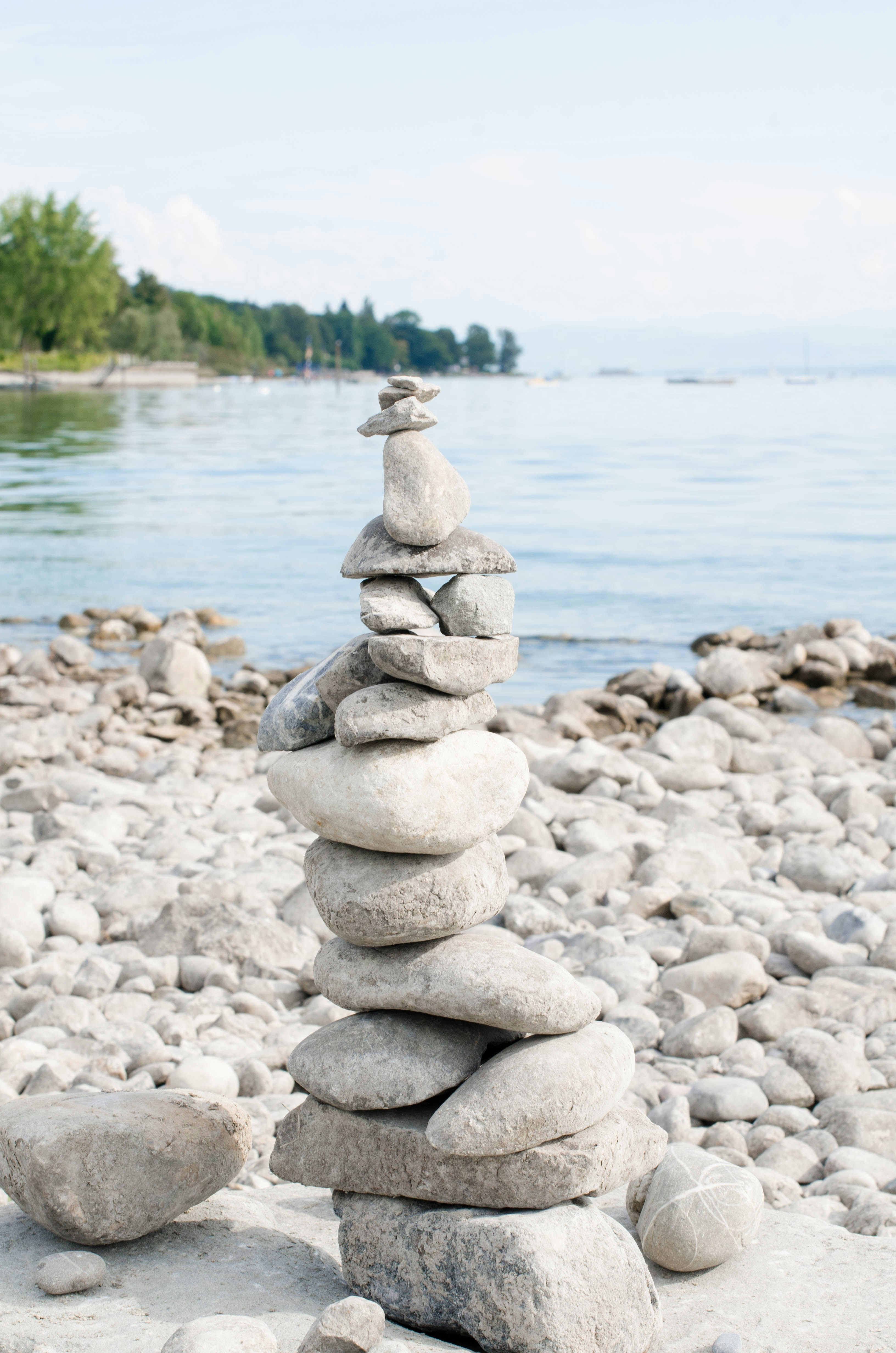 A large pile of rocks by a body of water photo – Free Travel Image on ...