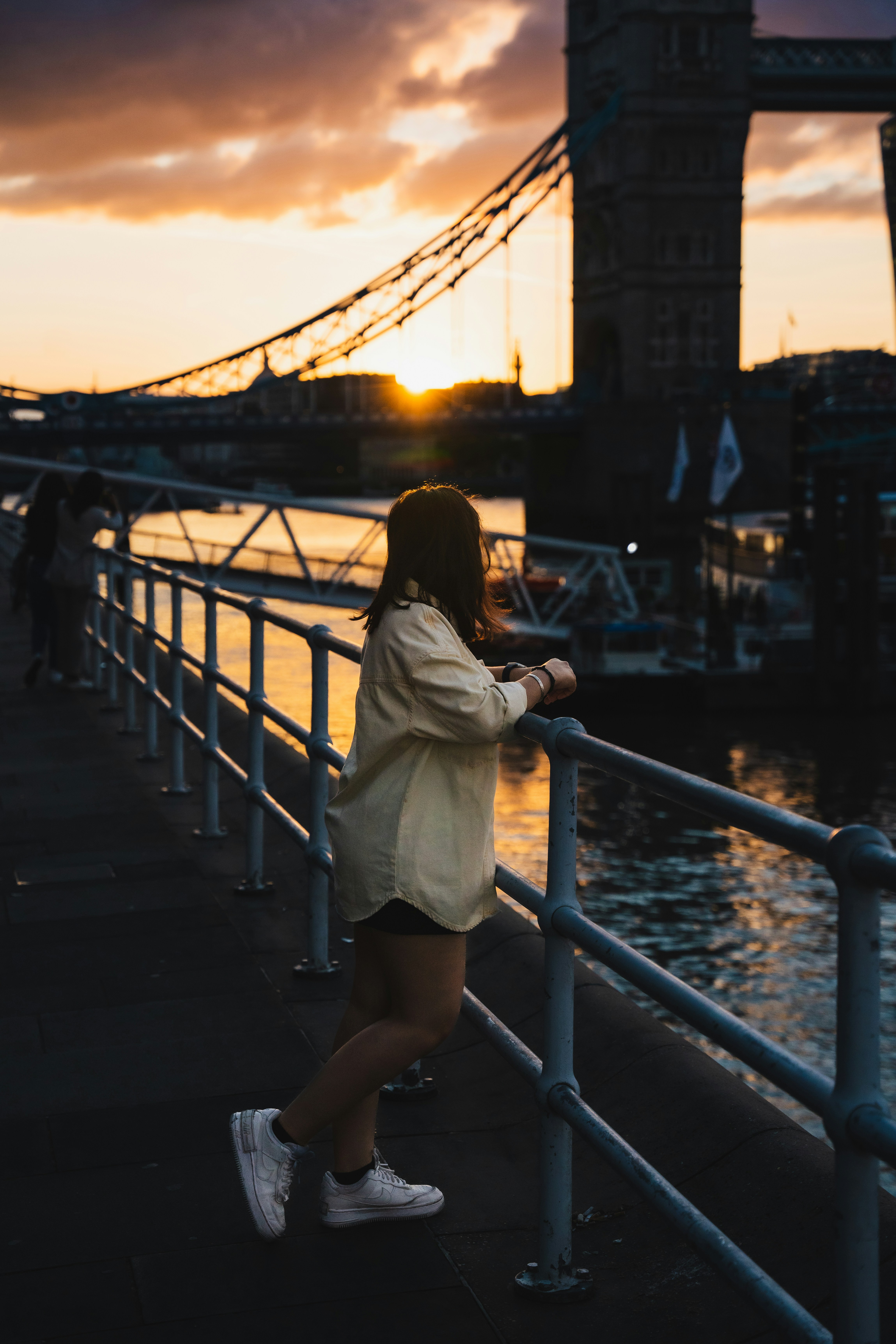 A person leaning on a railing looking at a sunset photo – Free City ...