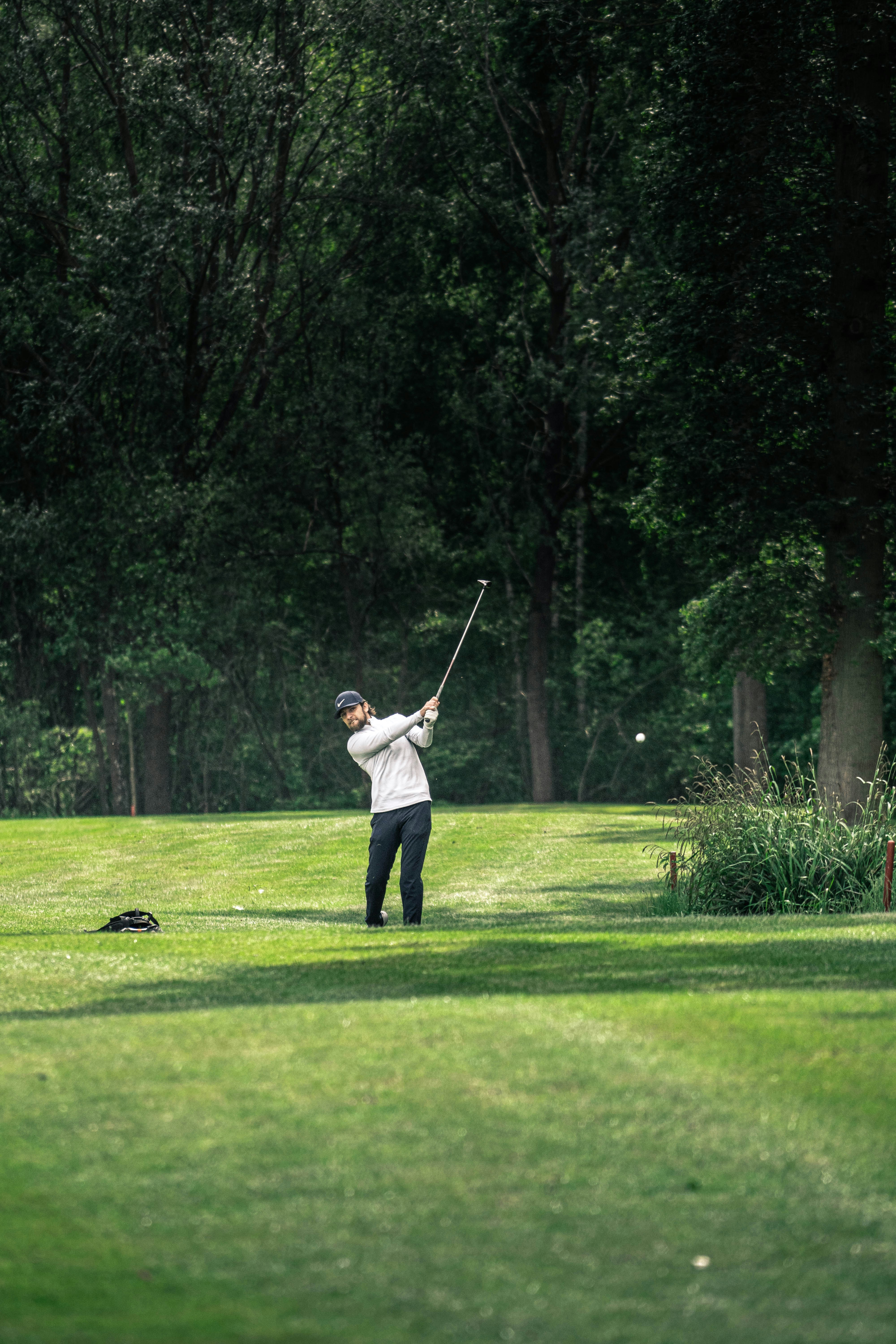 A person swinging a golf club photo – Free Golf de l'isle adam Image on ...