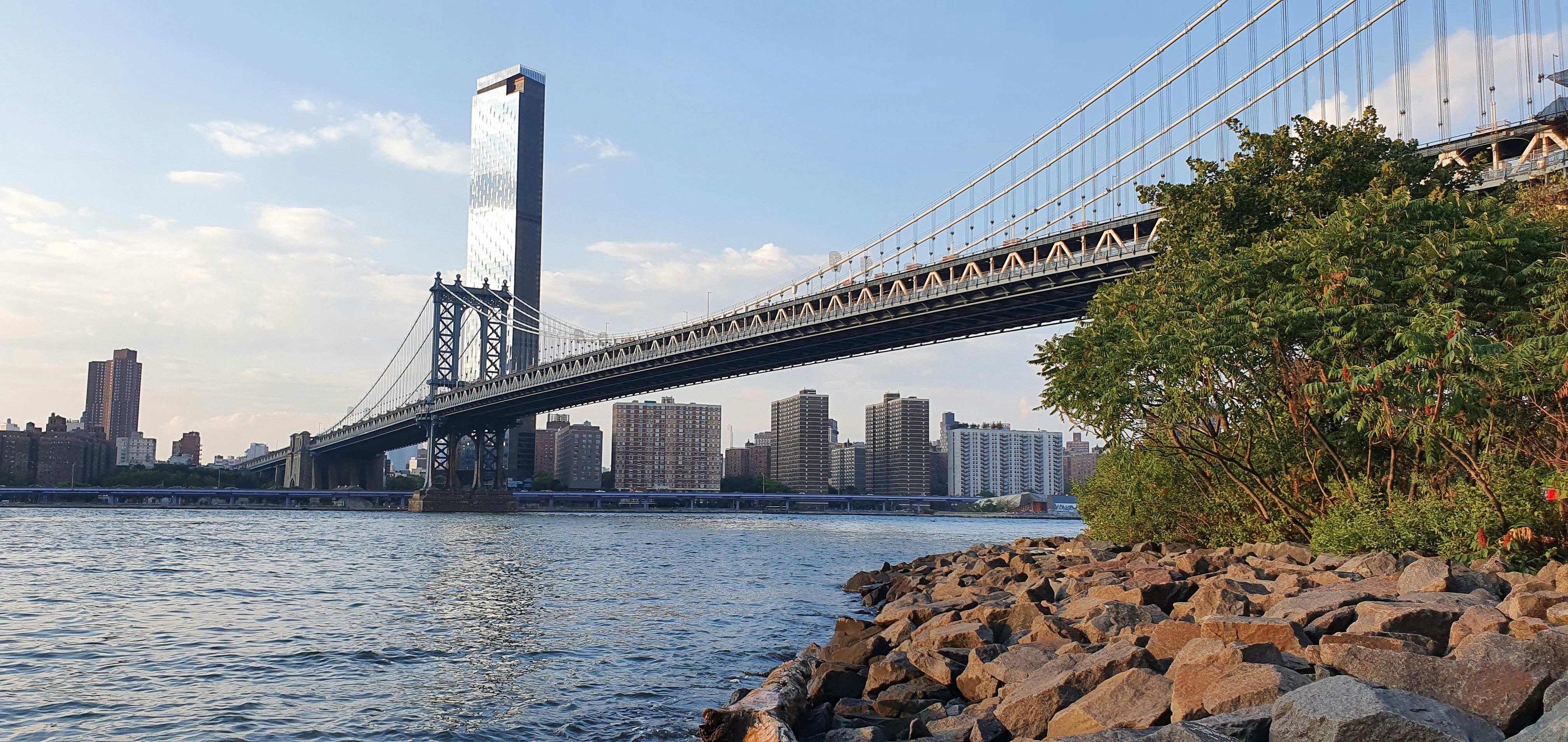 Riverside Steel: Suspension Bridge Framing a City Skyline at Daybreak