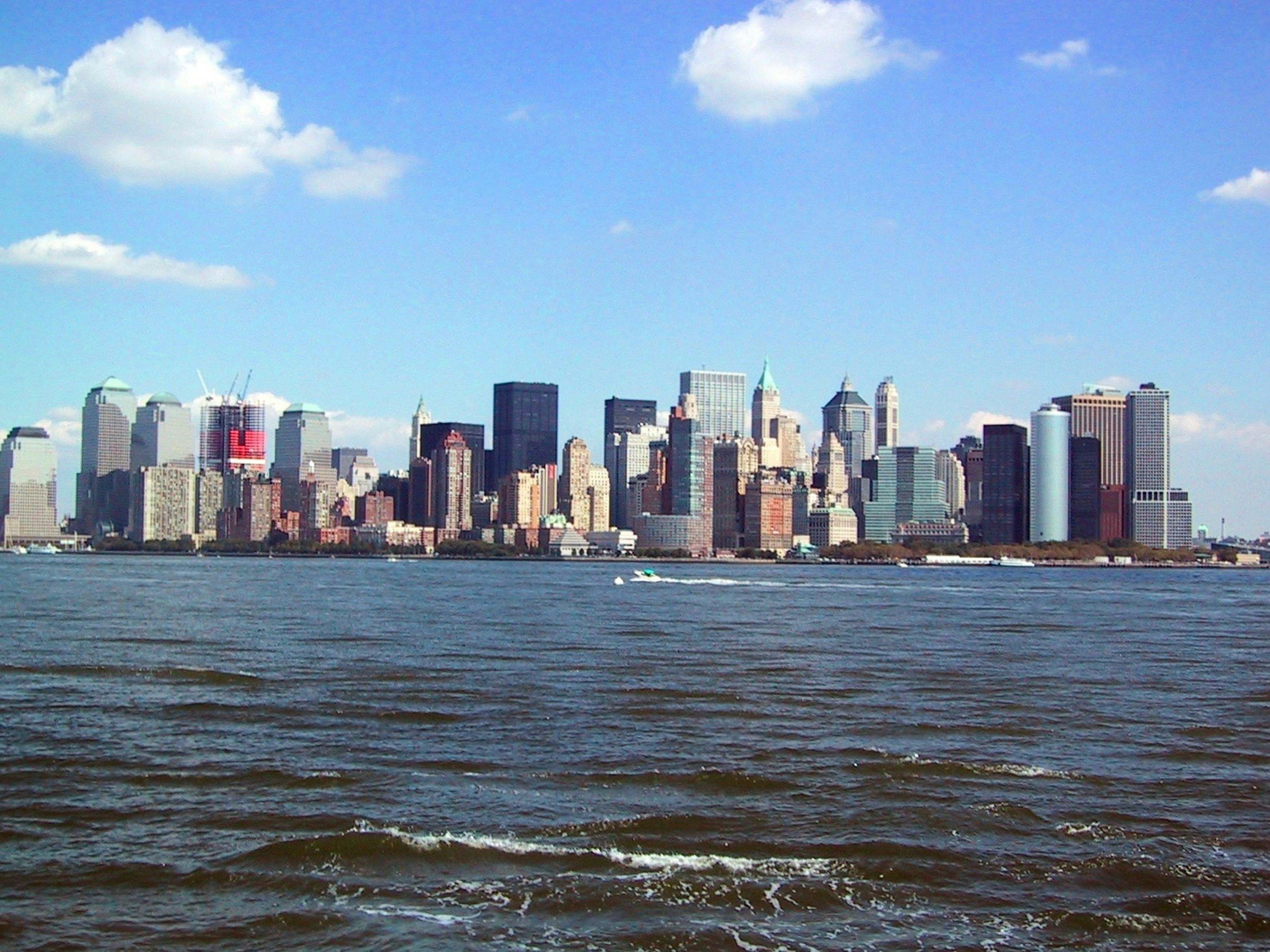 A panoramic view of a bustling city skyline reflected in the water, showcasing a blend of modern architecture and natural elements.