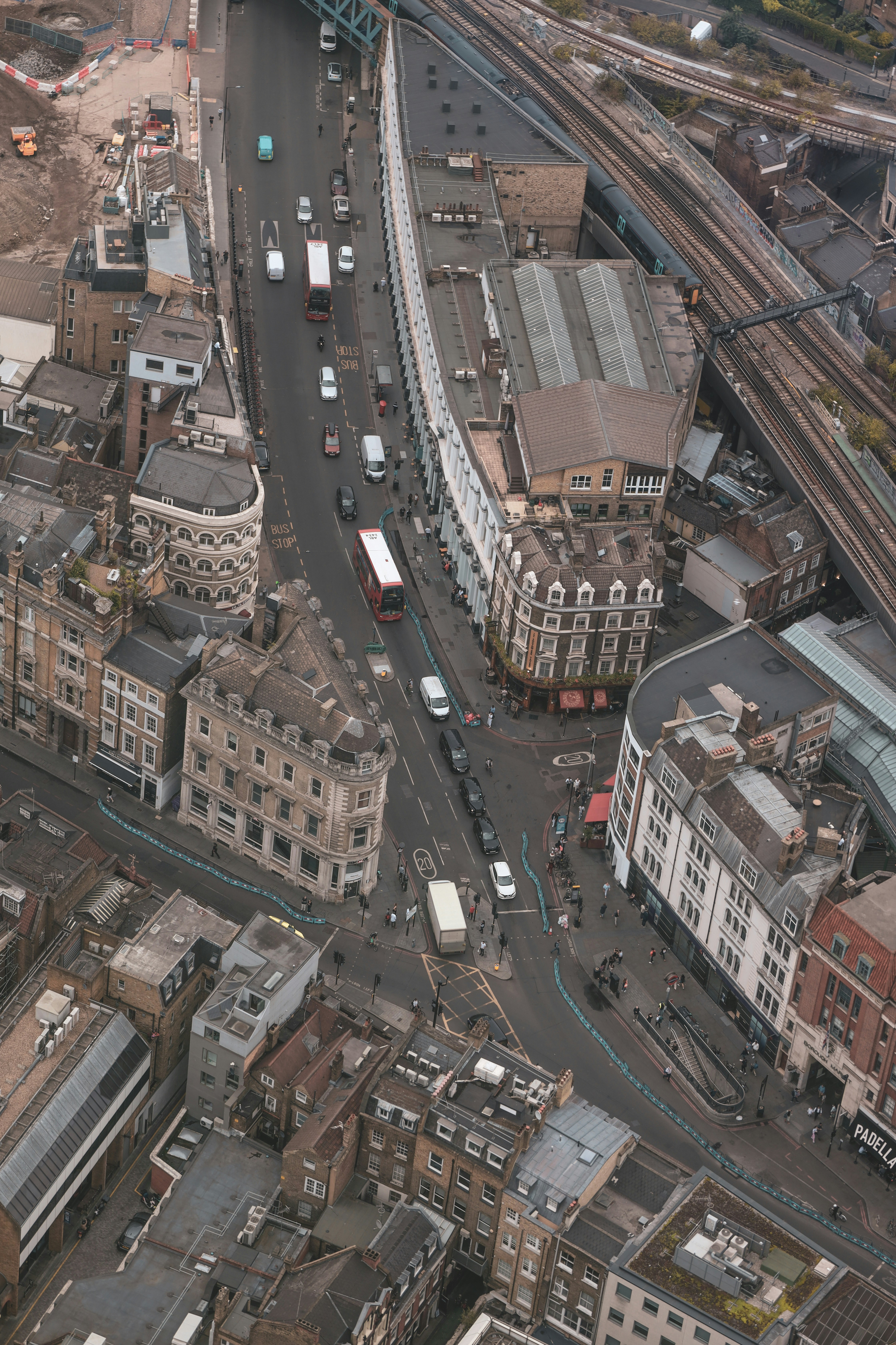 Aerial perspective of a bustling city intersection, showcasing a blend of historic and modern architecture, with vehicles navigating the streets below.