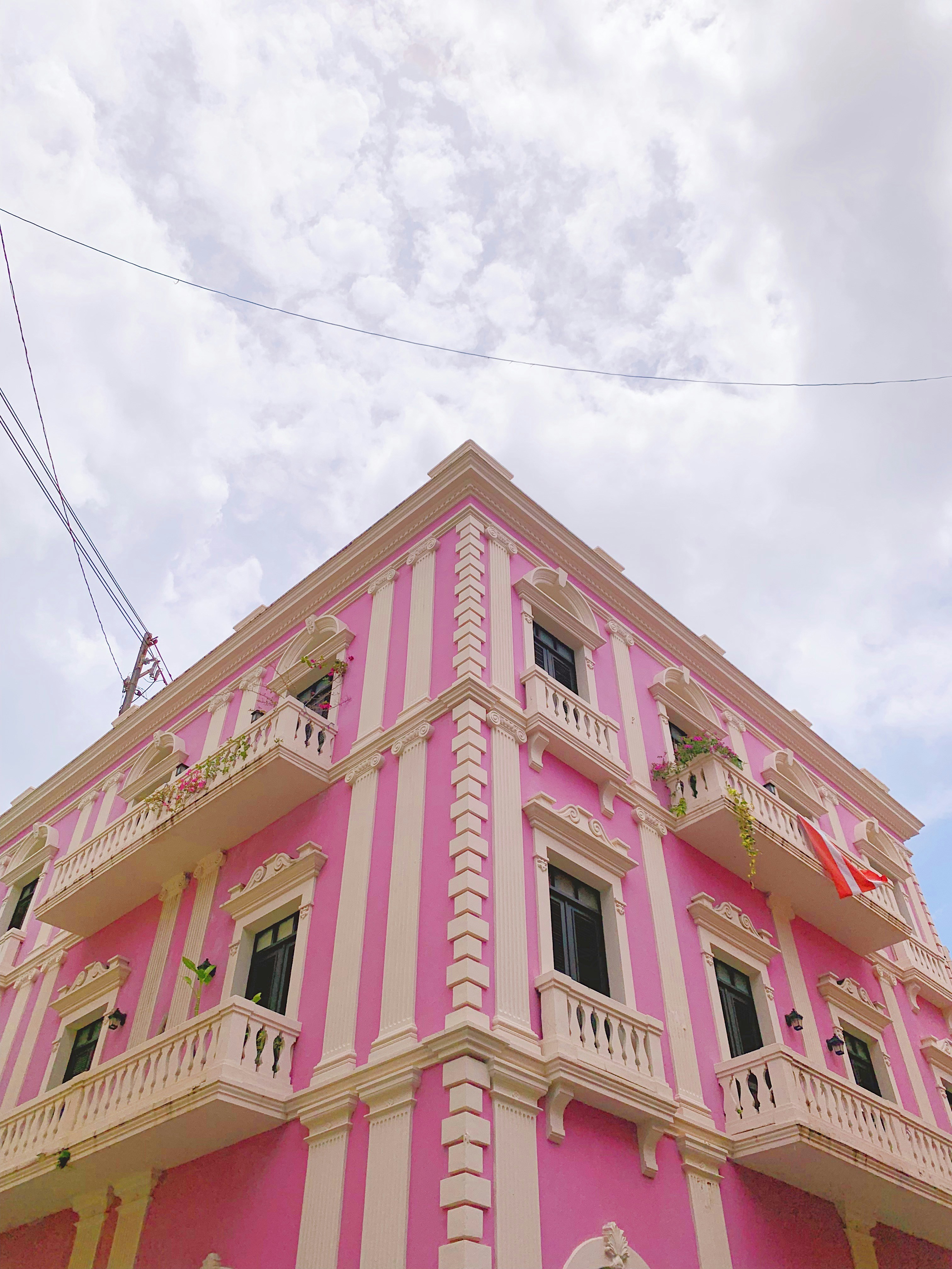 A pink building with a white roof photo – Free San juan Image on Unsplash