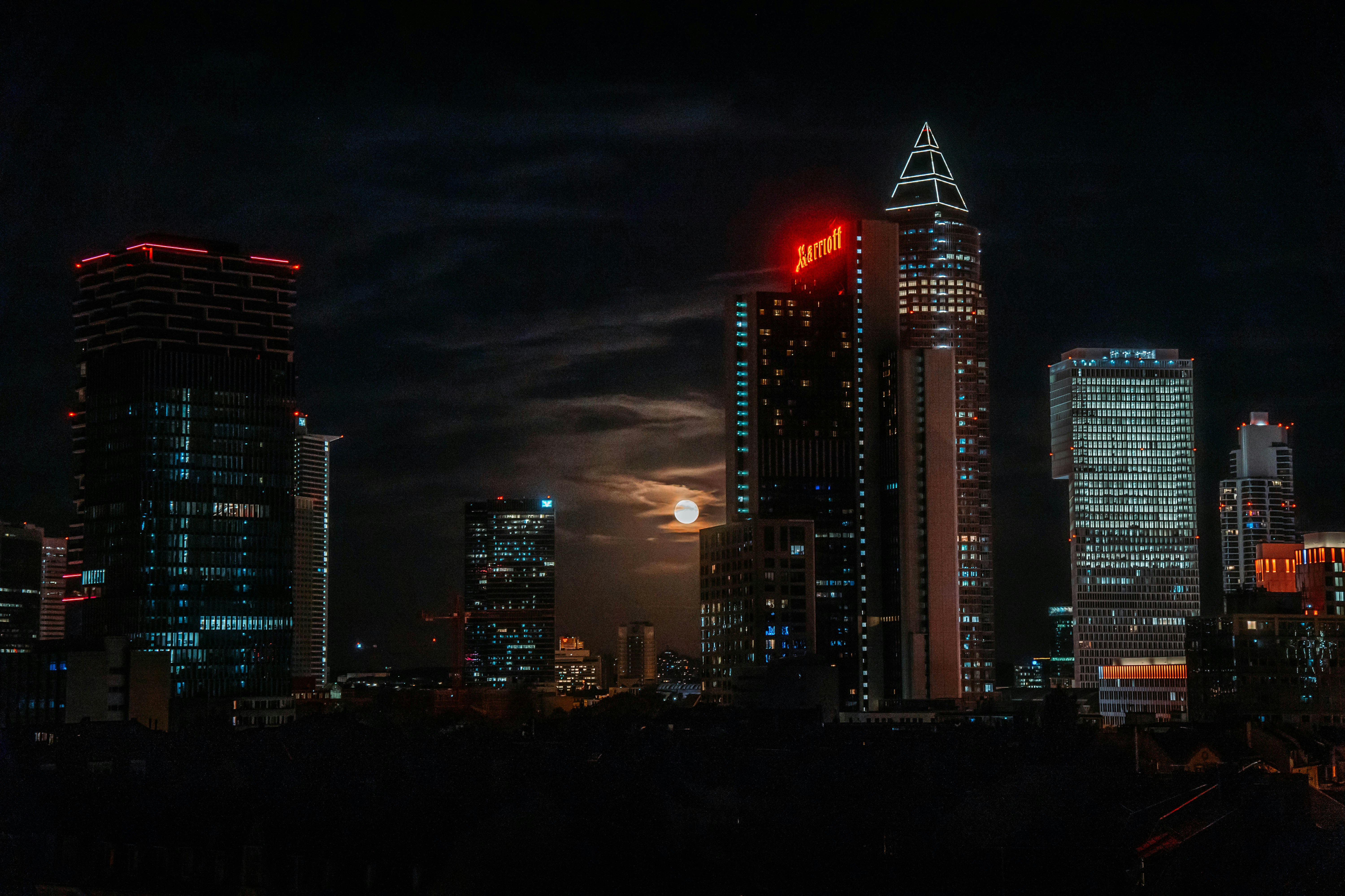Moonrise Behind Neon Towers: A Midnight Cityscape