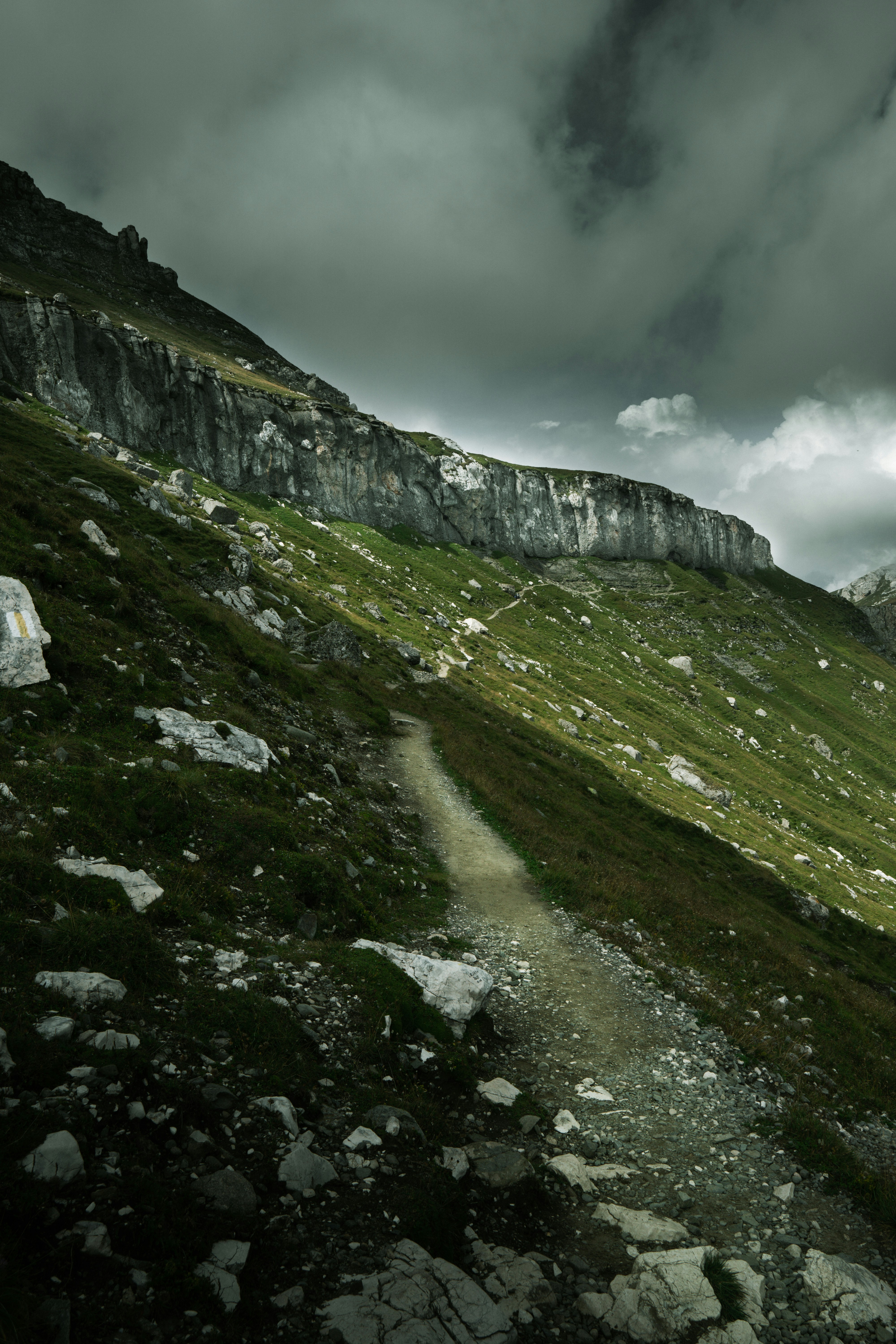 Winding Cliffside Trail Under Looming Storm Clouds