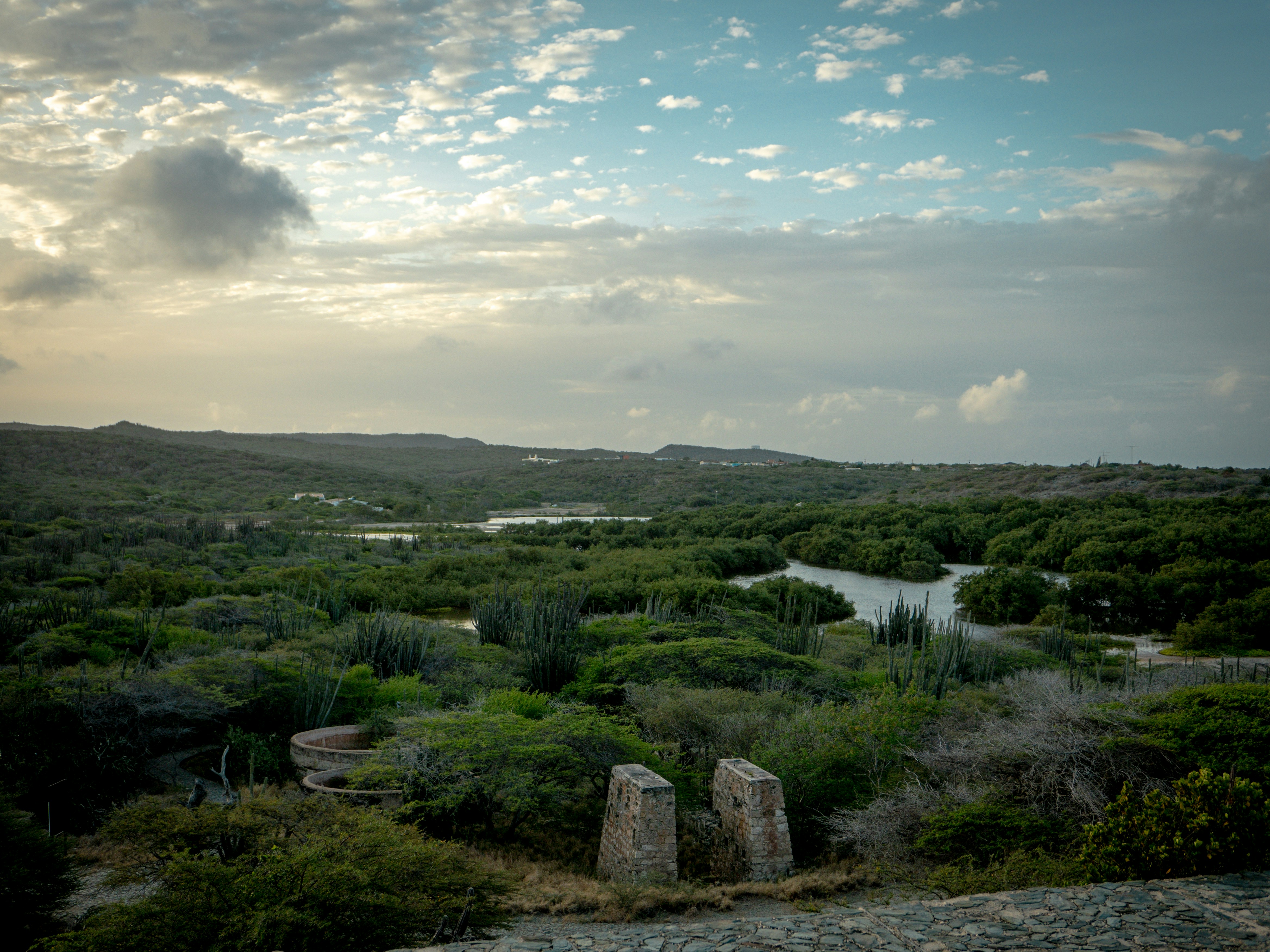 Stone Pillars Over a Quiet River Bend at Dusk