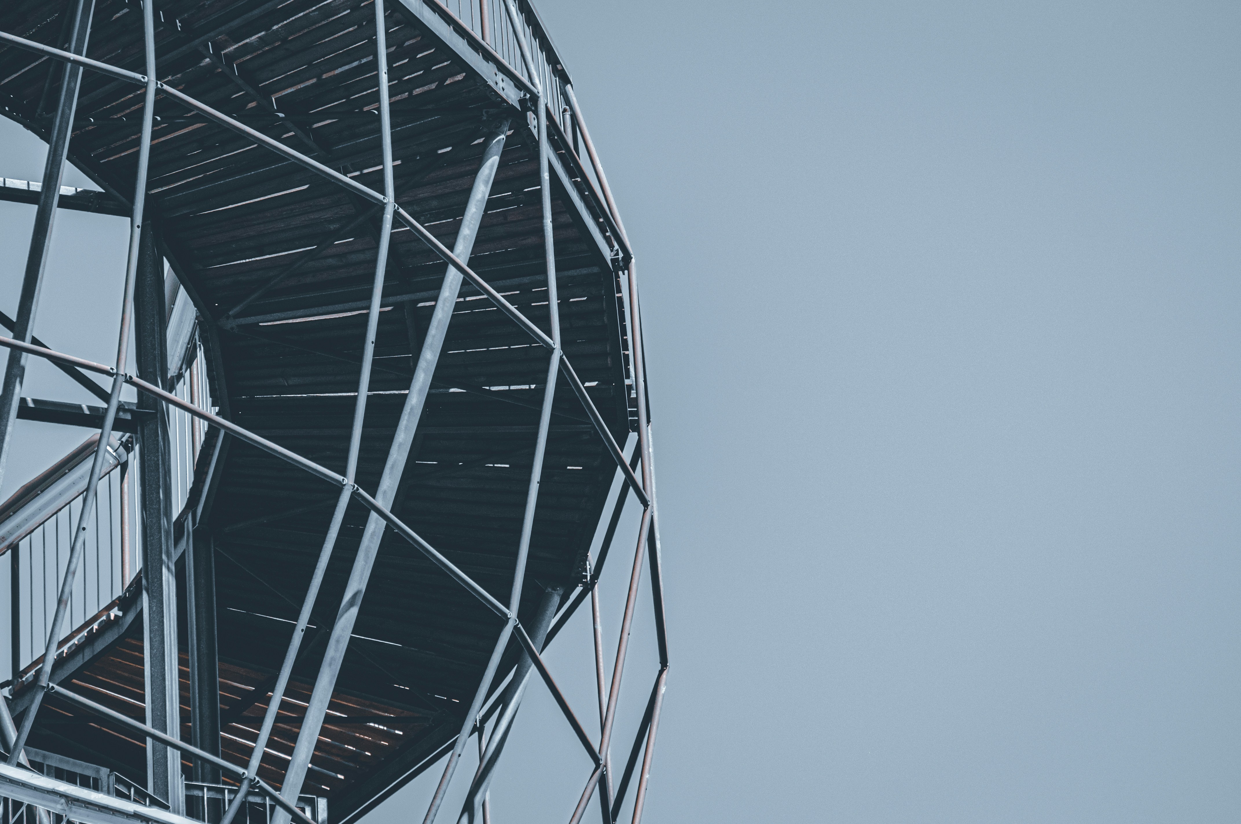 Spiral Framework: Close-up of a Steel Observation Structure Against Quiet Sky