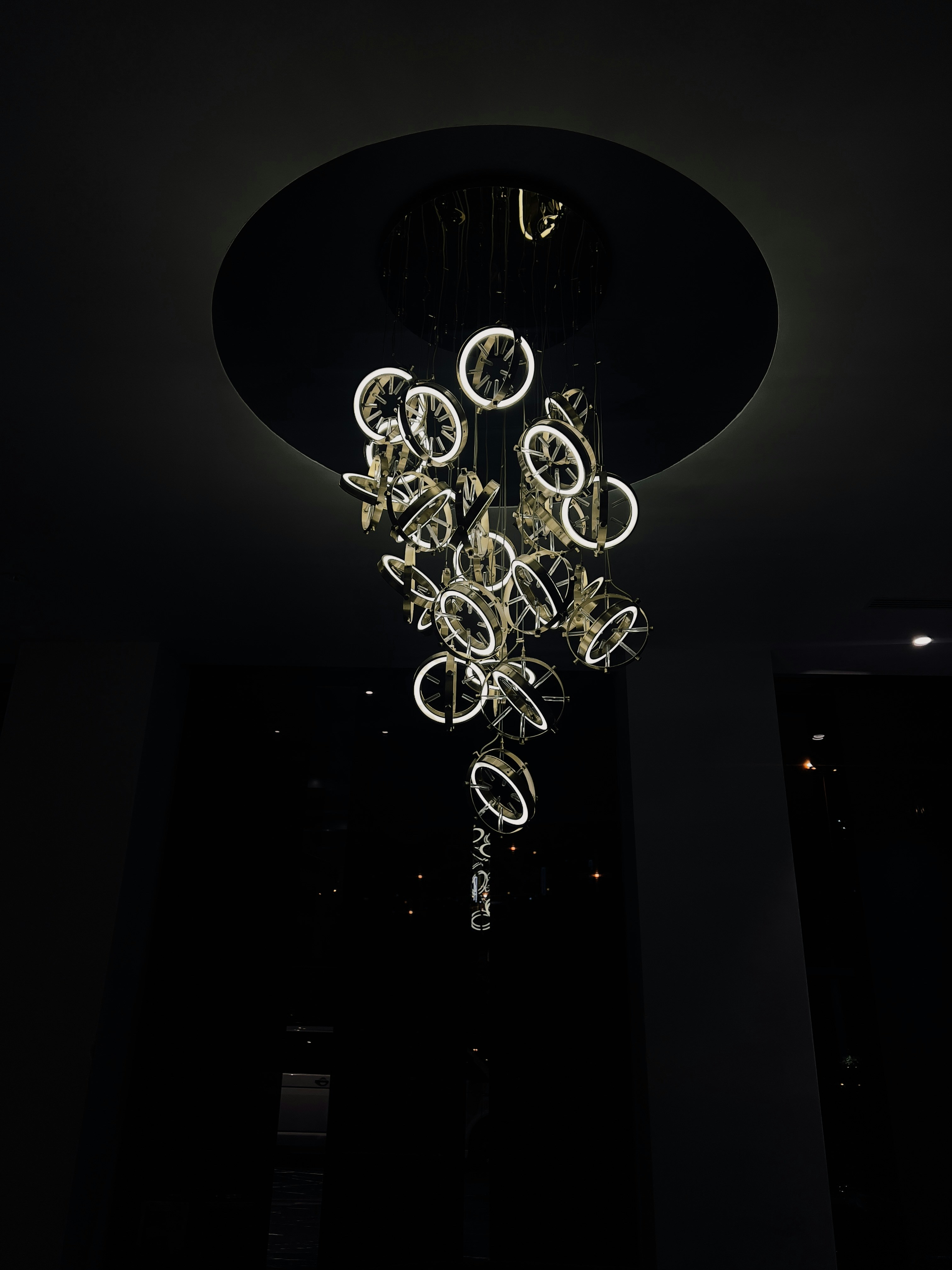 Orbital Glow: A Vertical Cascade of Neon Rings in a Dark Atrium