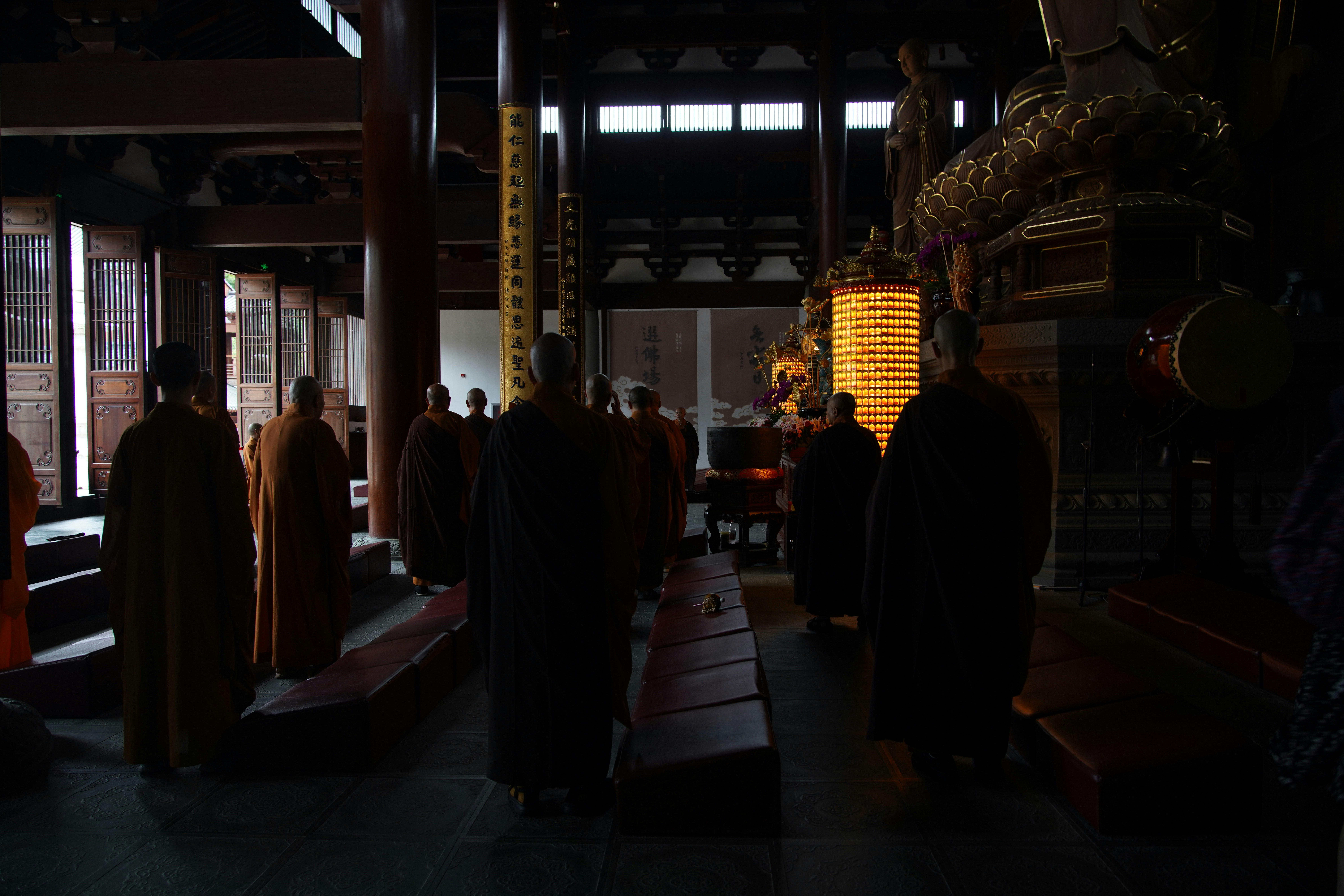 a group of people in robes standing in a room with a large chandelier and a large