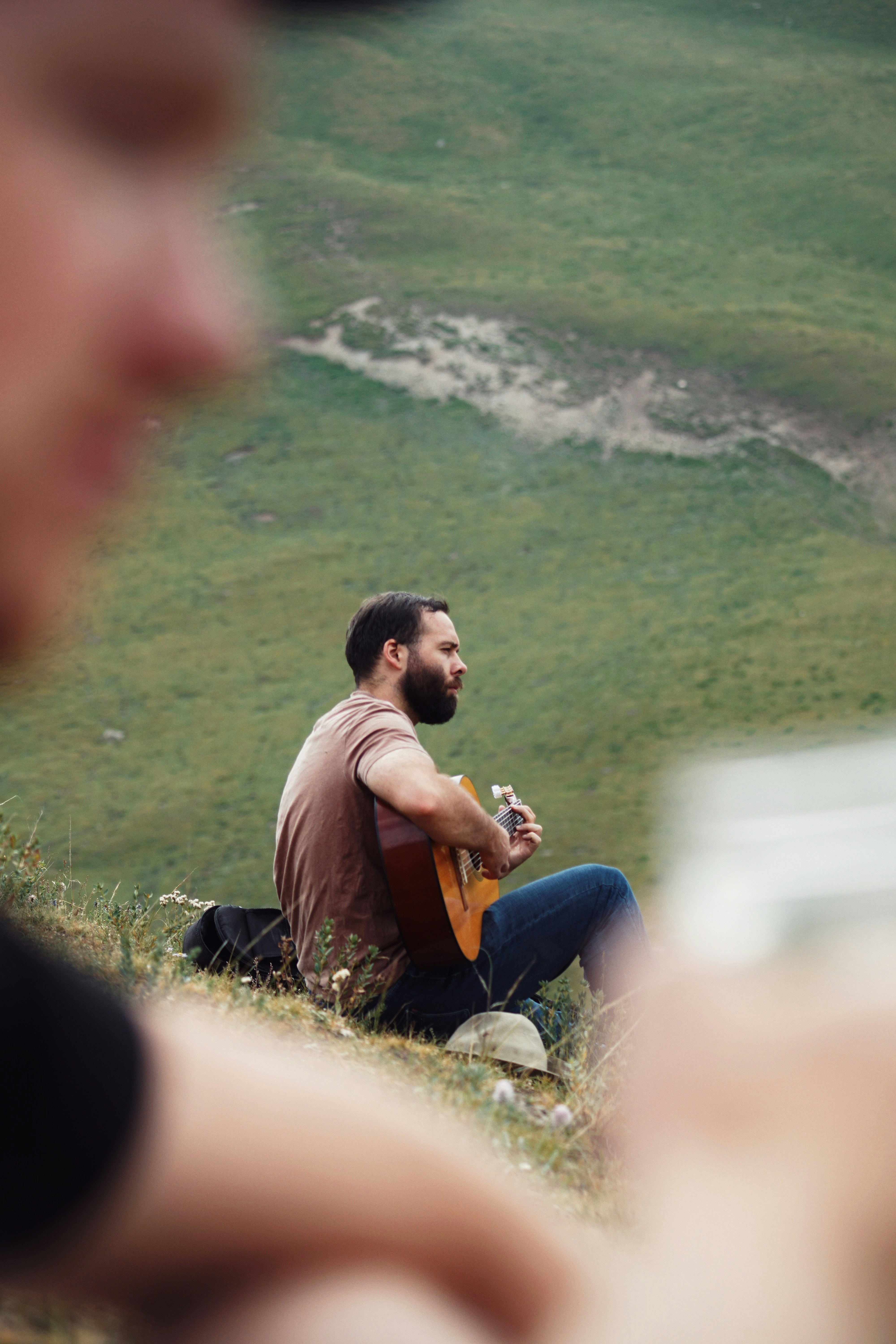 Meadow Serenade: A Lone Guitarist Framed by Rolling Hills