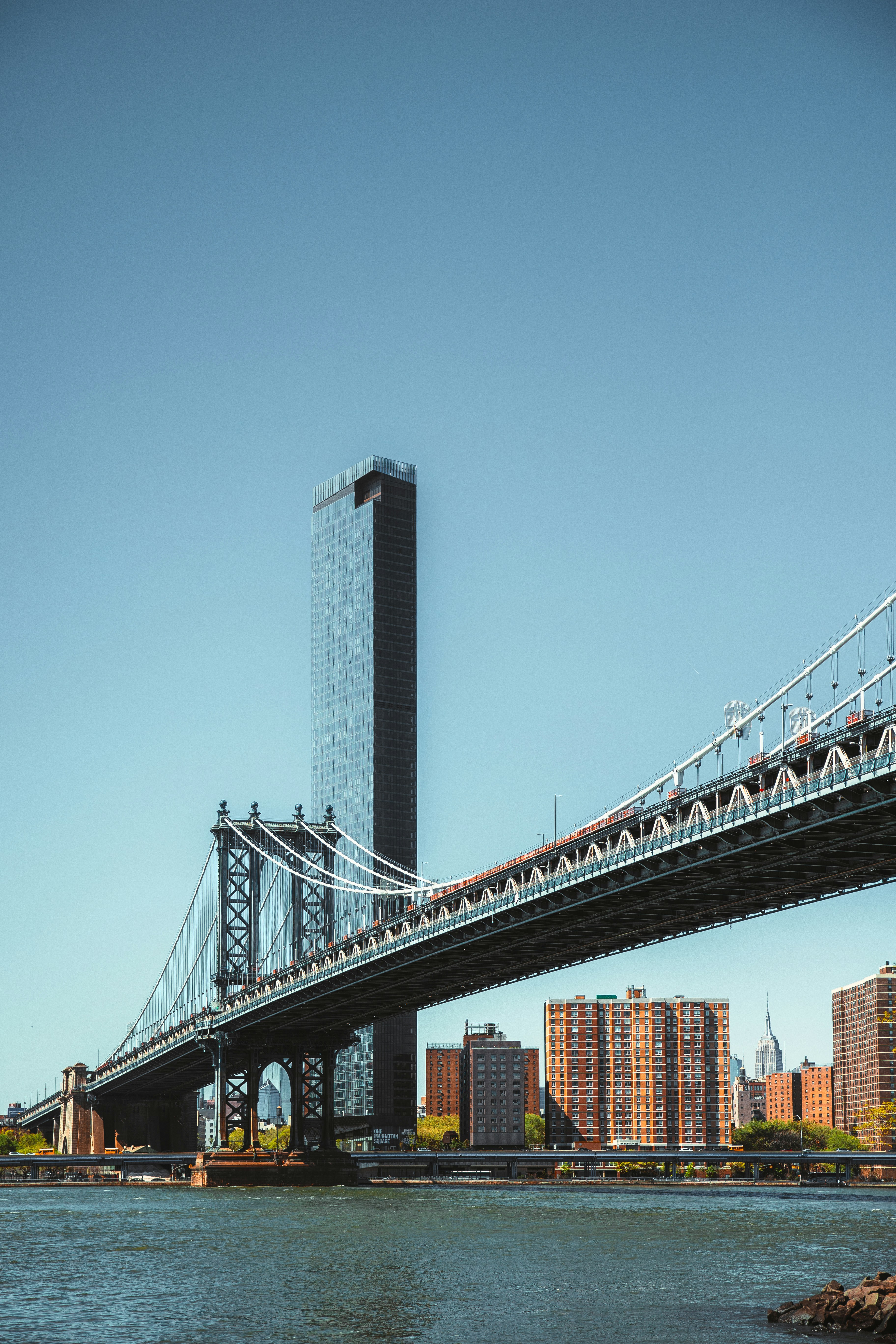 a bridge over water with a tall building in the background