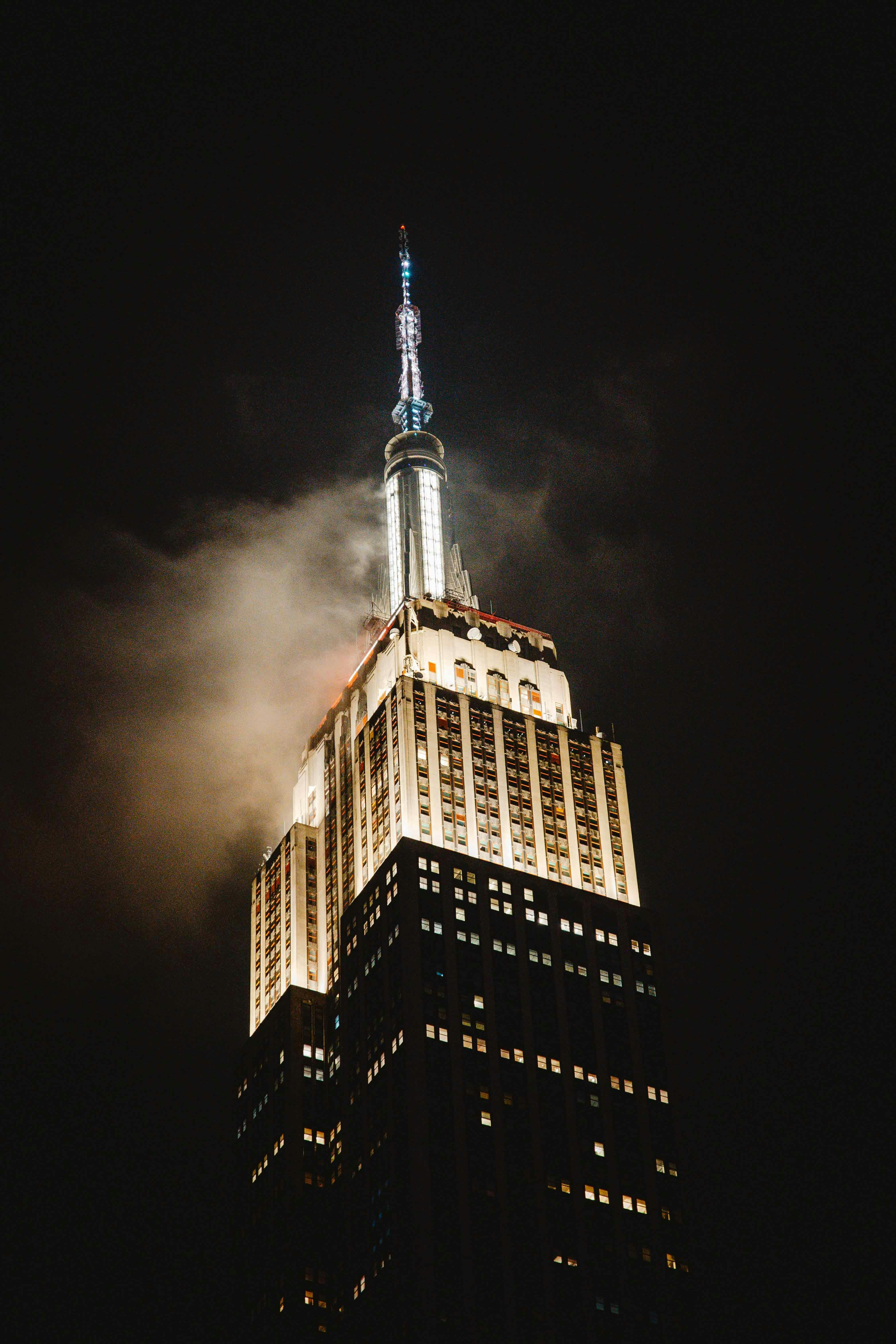 A tall building with a pointy top at night photo – Free New york Image ...