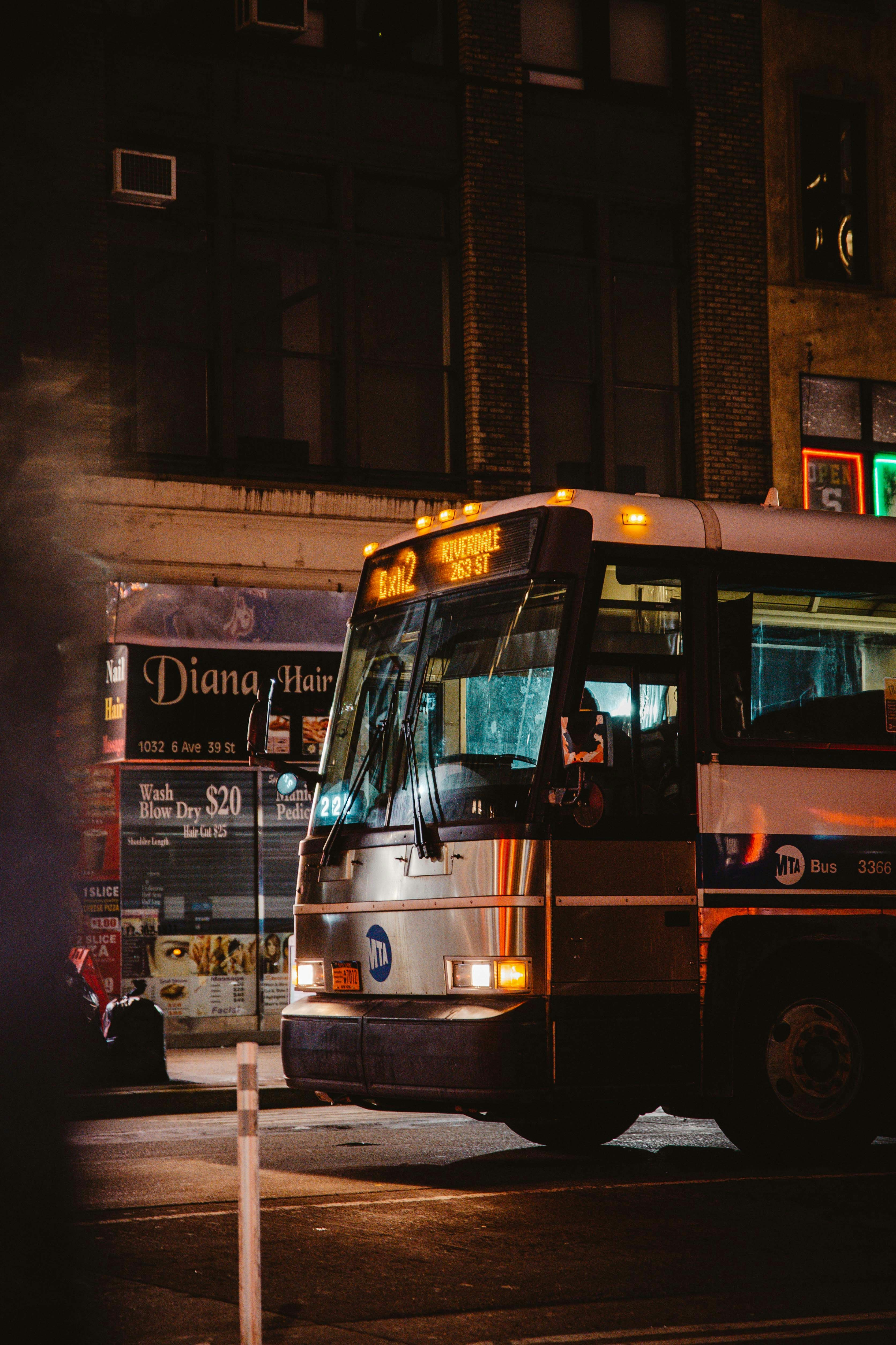 Neon-Glazed Front: A Night Bus Anchors the Street