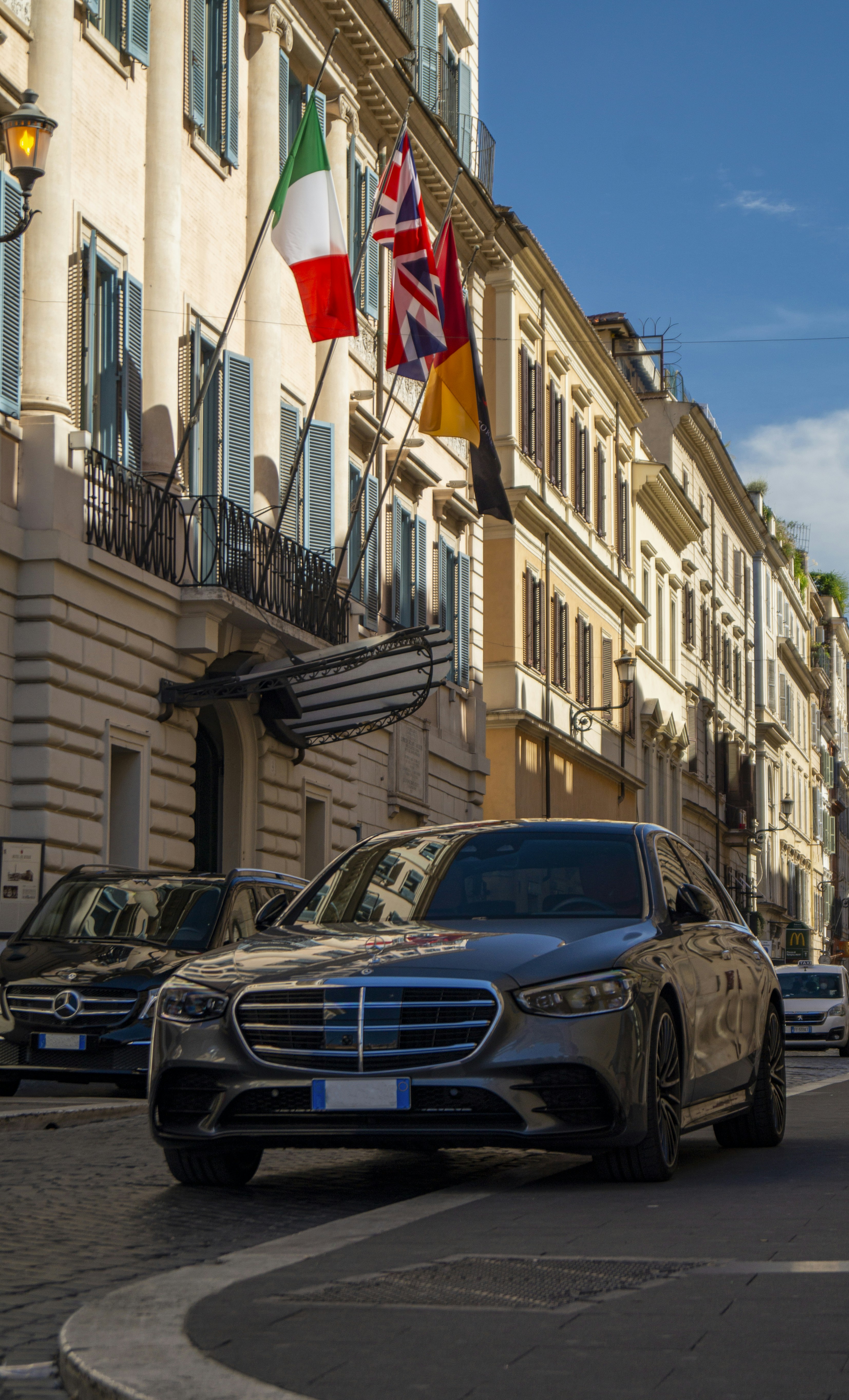 Voitures garées sur le côté d’une rue avec des drapeaux sur le côté ...