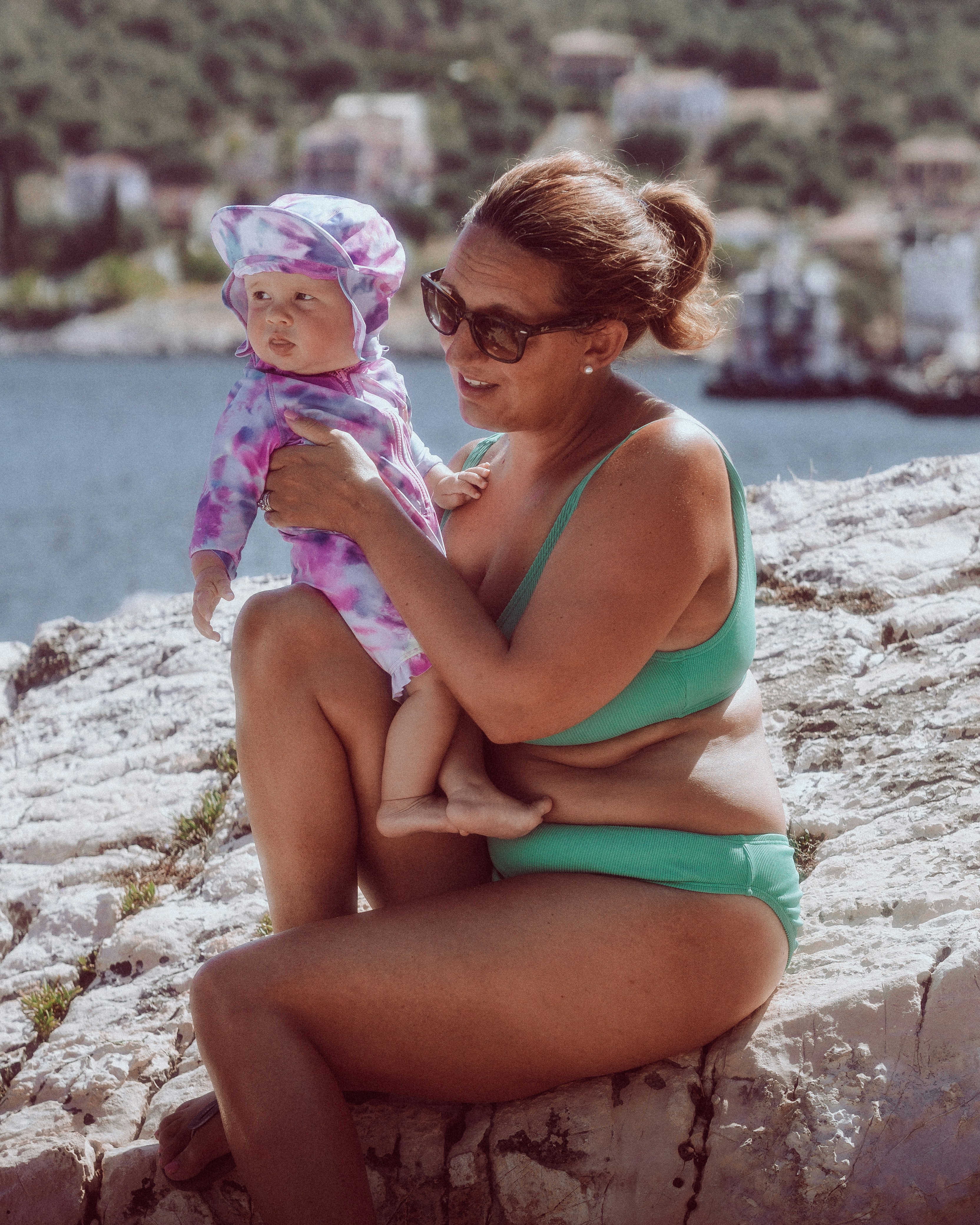 Mother and Child on Coastal Rocks: Sunlit Tranquility by the Sea