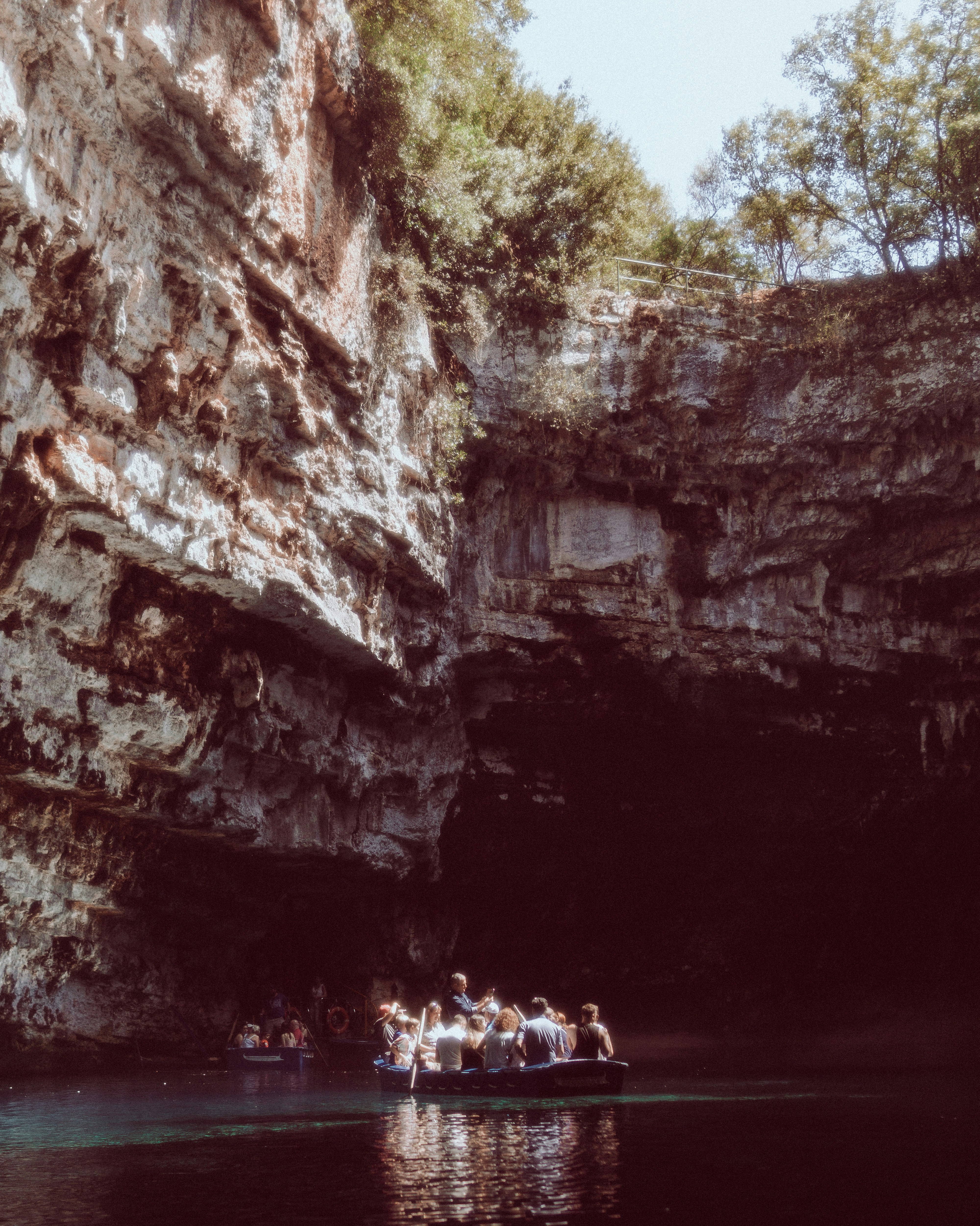 a group of people in a boat in a river between large rock cliffs