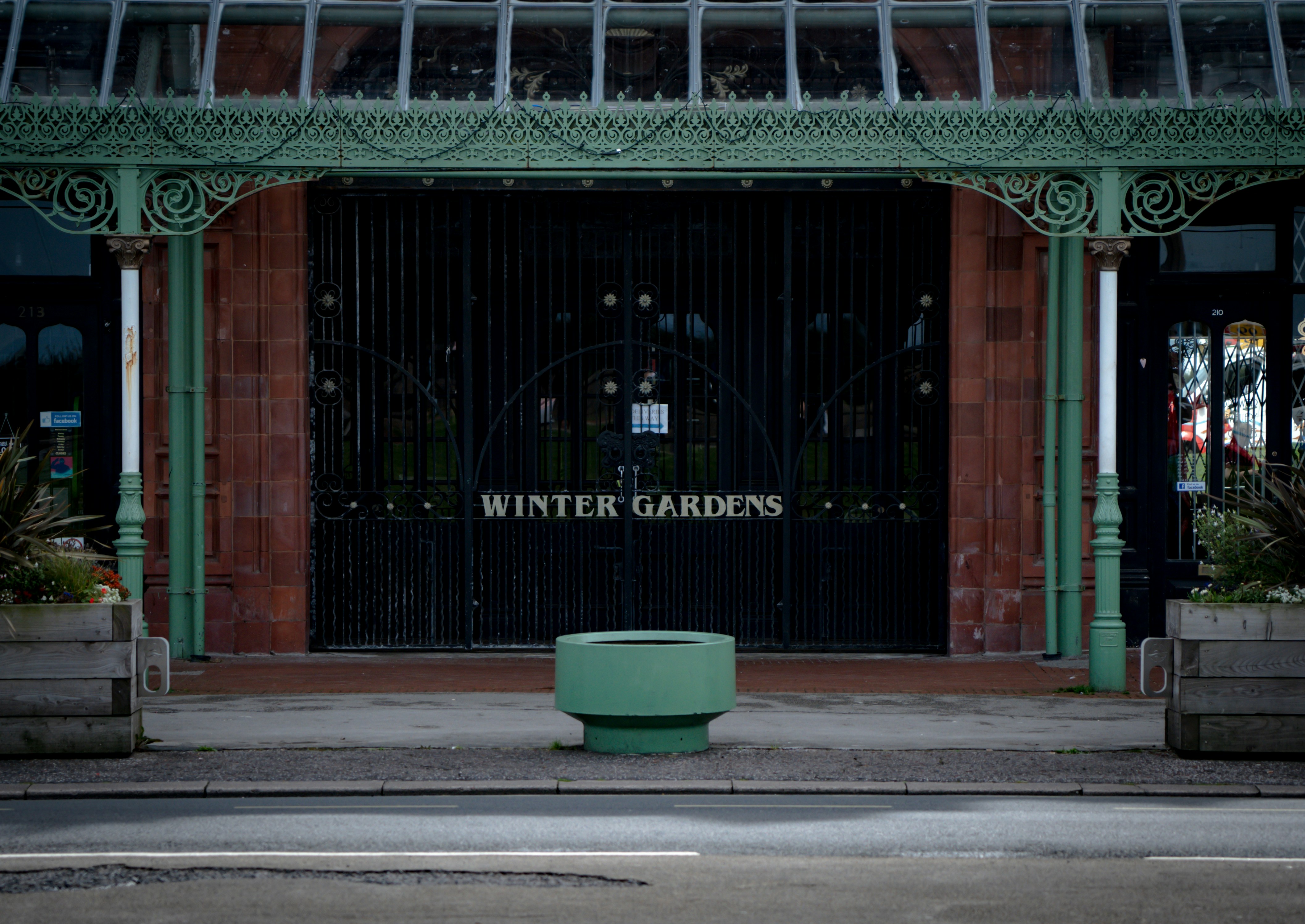 Entrance to Winter Gardens with ornate green ironwork and closed doors.
