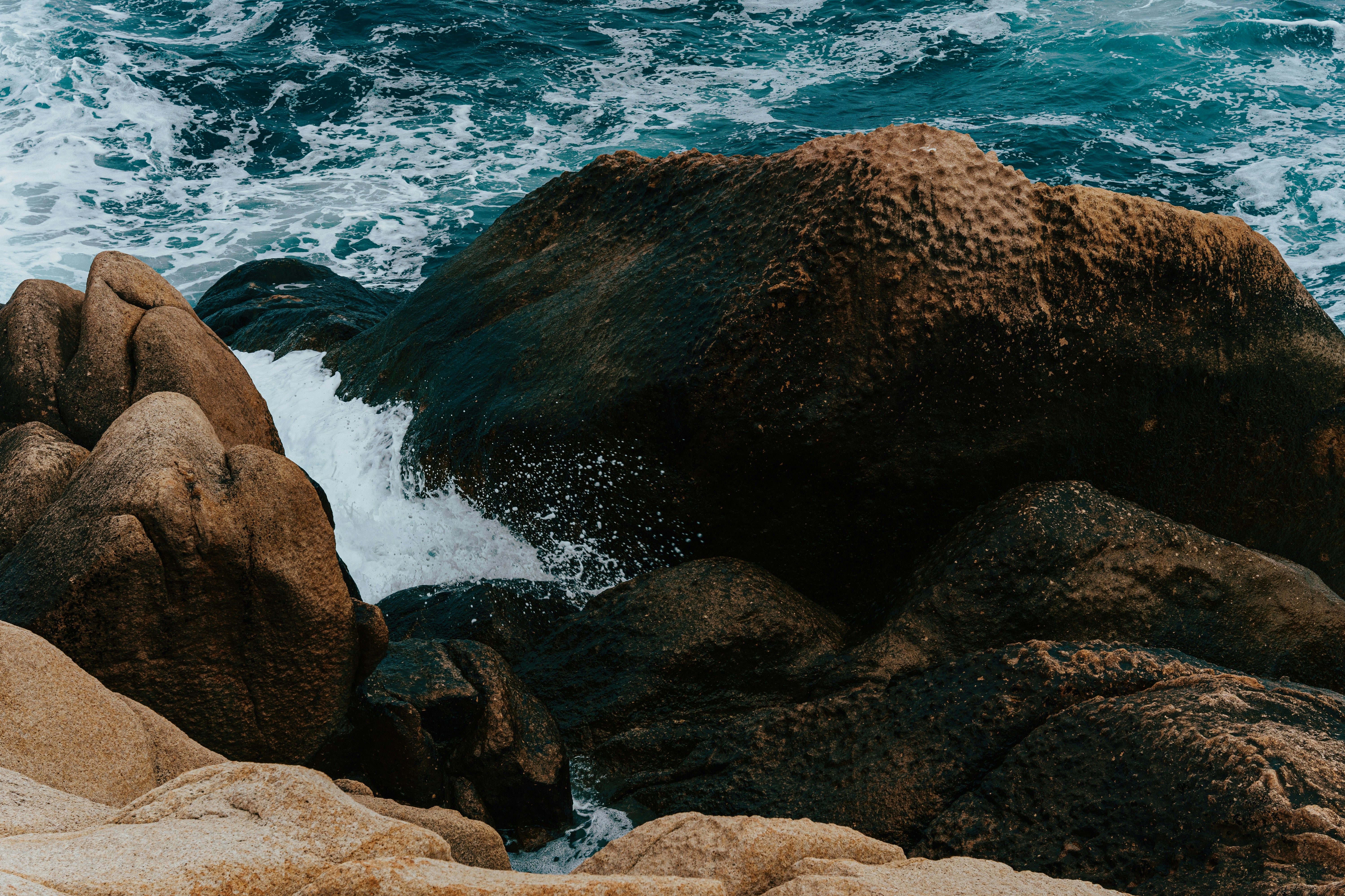 A group of rocks by the water photo – Free Sea Image on Unsplash