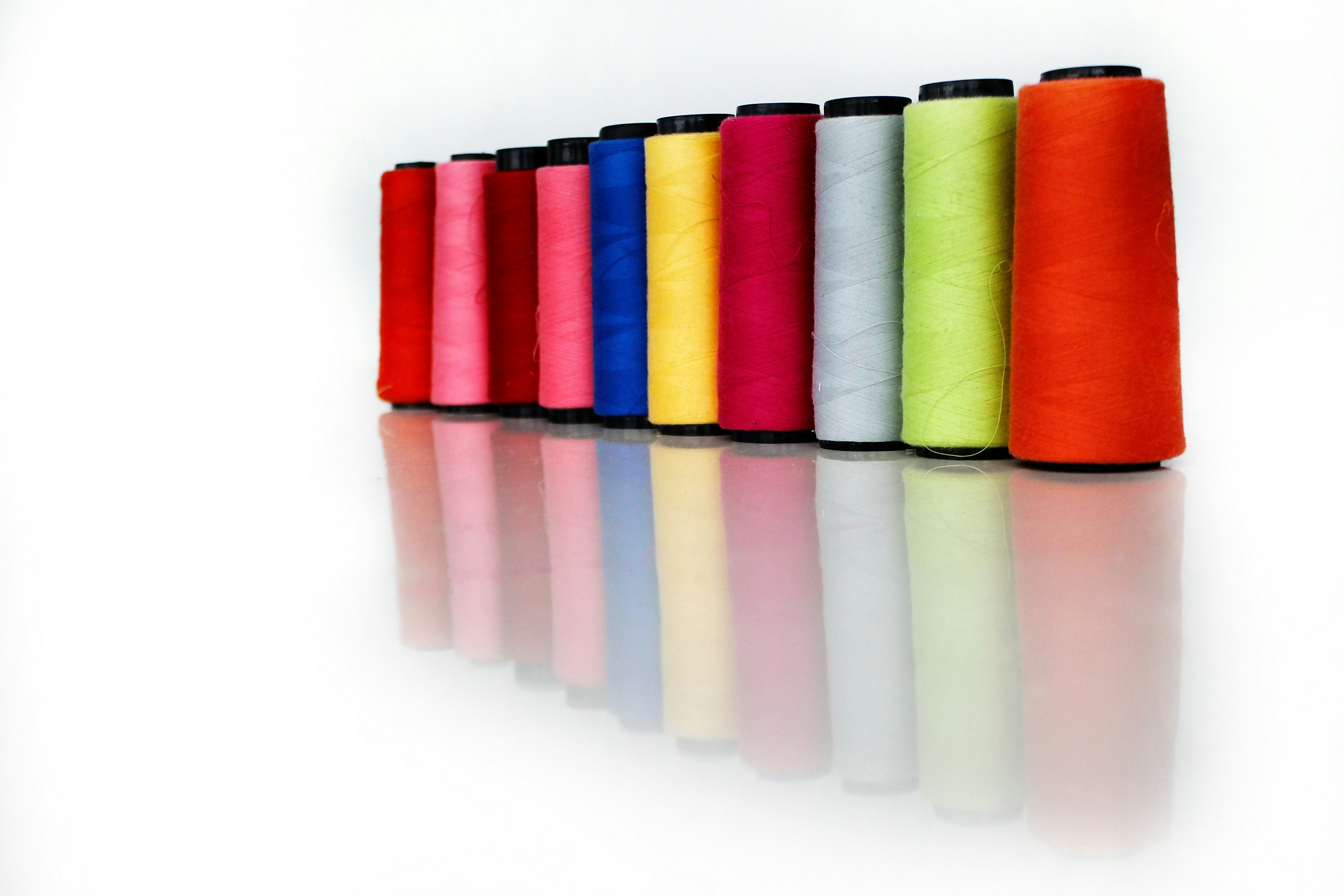 Colorful Spools in a Reflective Row