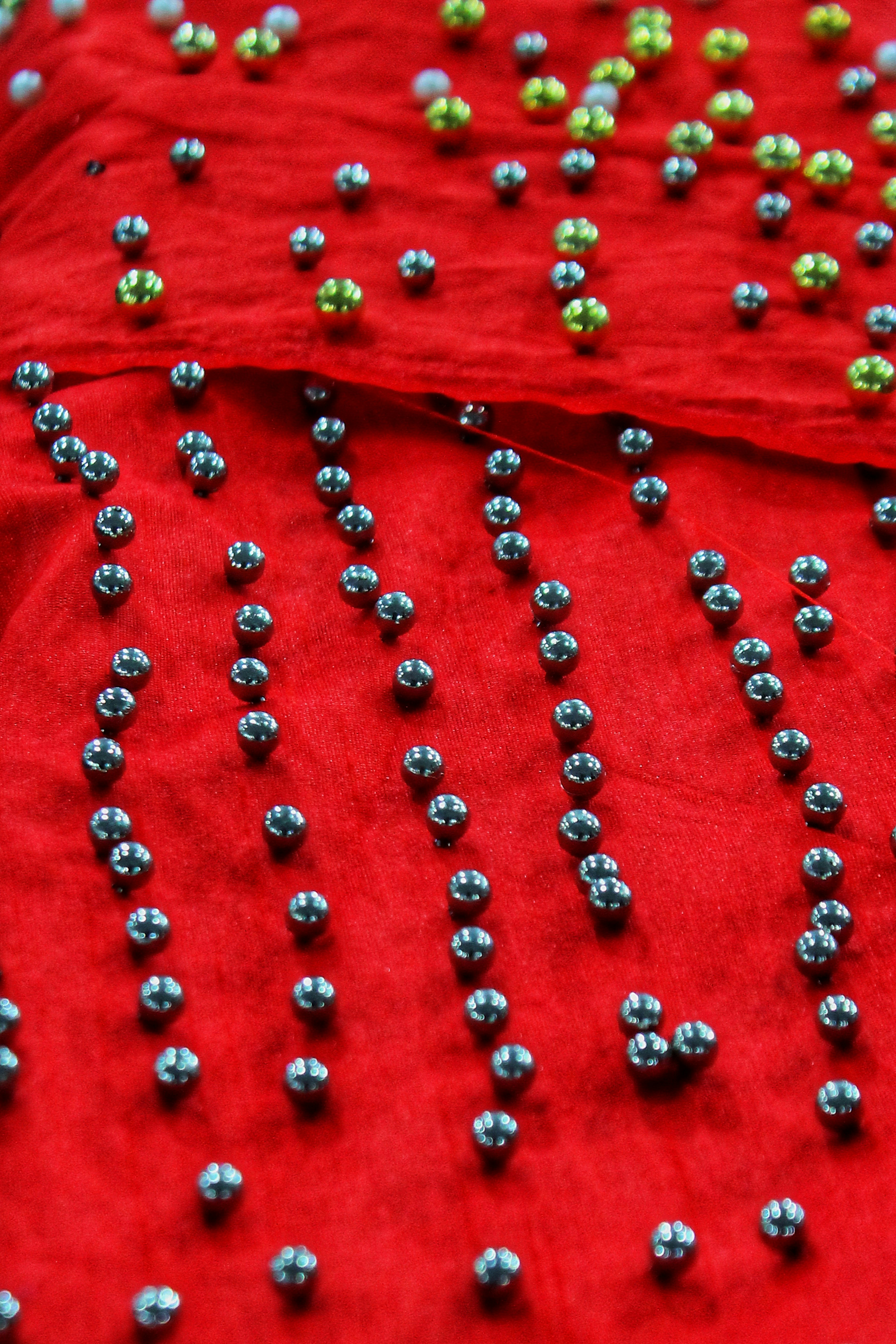 A red surface with many small round objects on it photo – Free ...