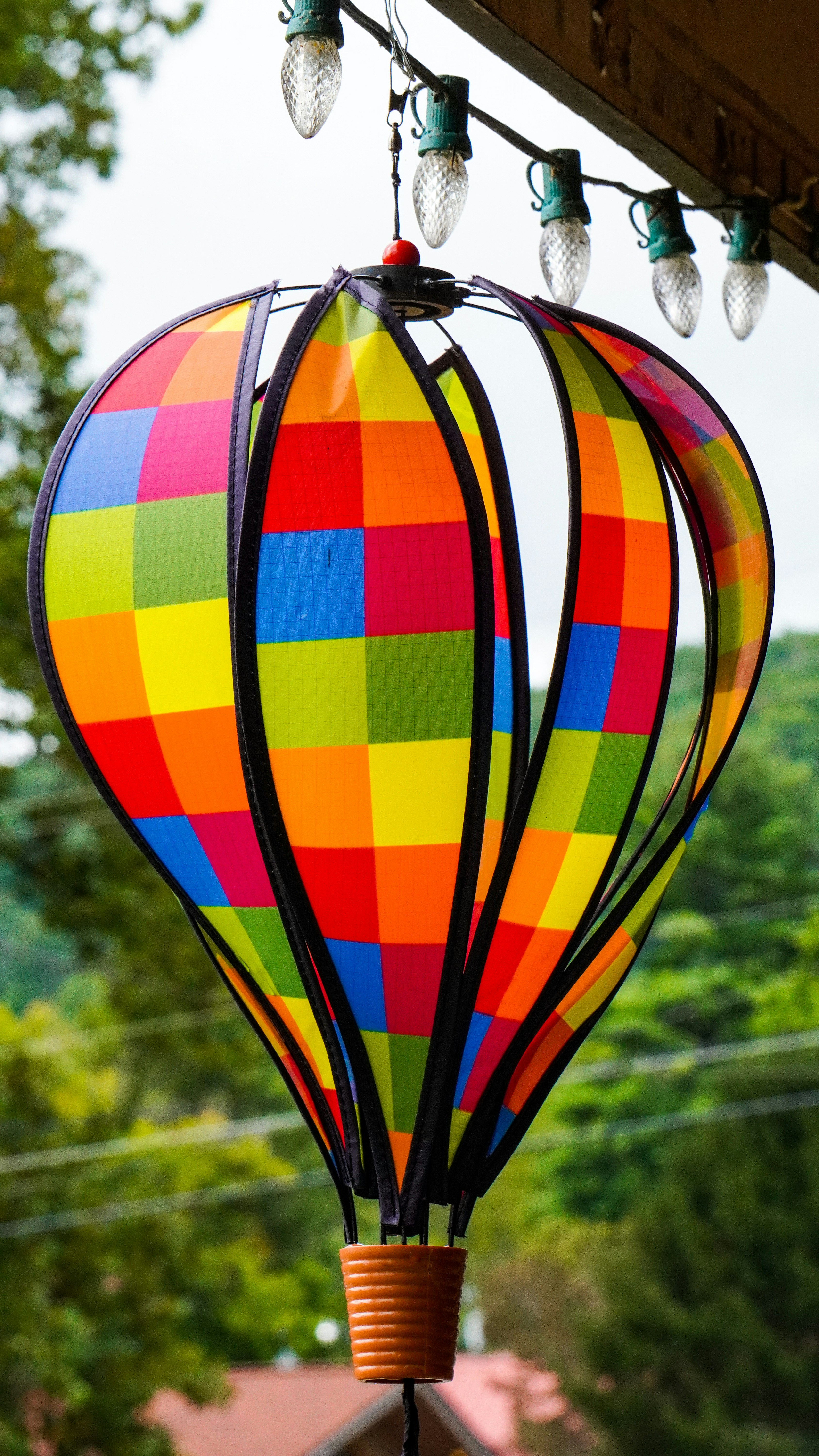 Patchwork Lantern Balloon: A Rainbow Tapestry Hanging Under String Lights