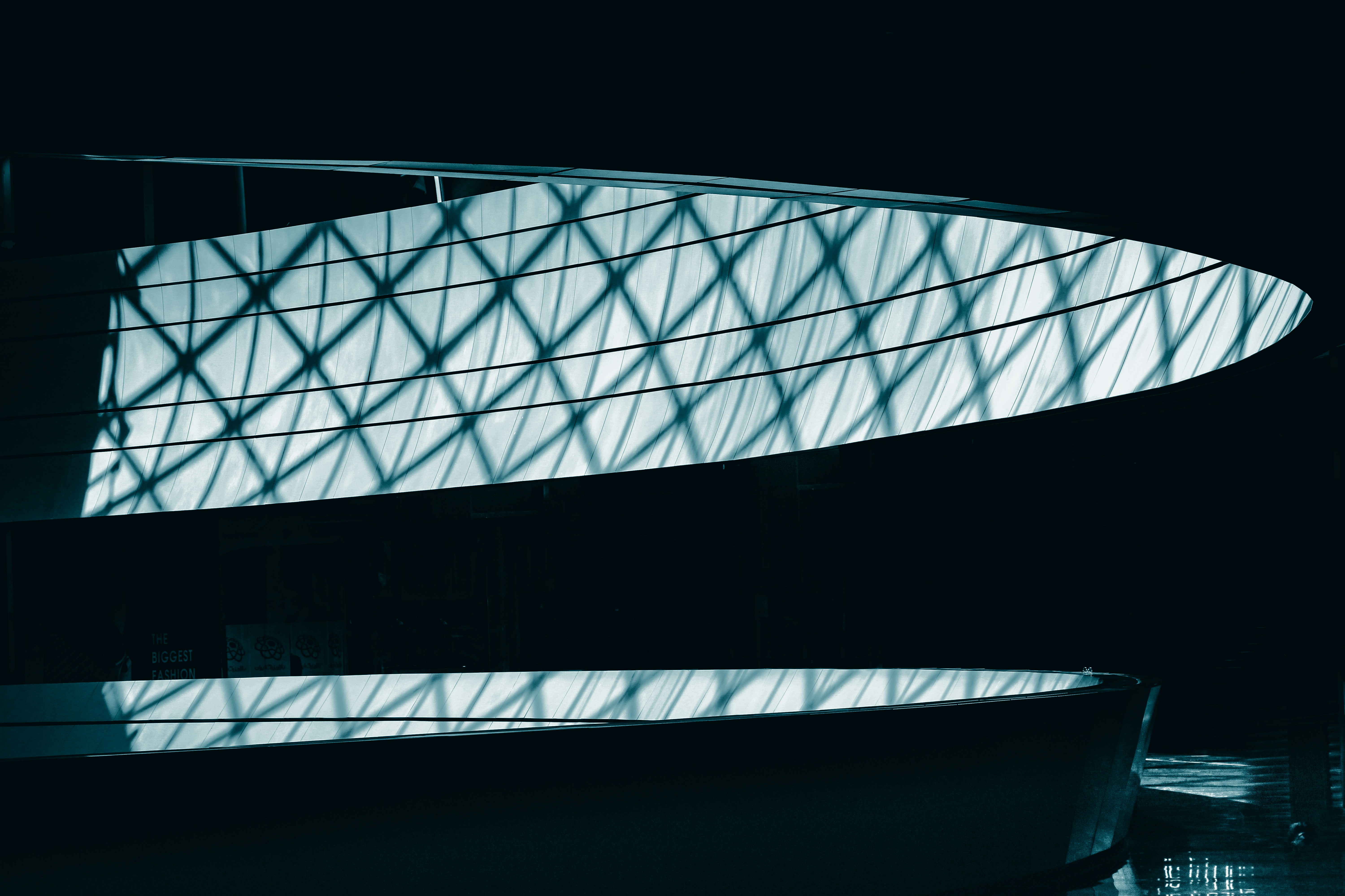 Cyan Lattice Arches Cut Through Darkness