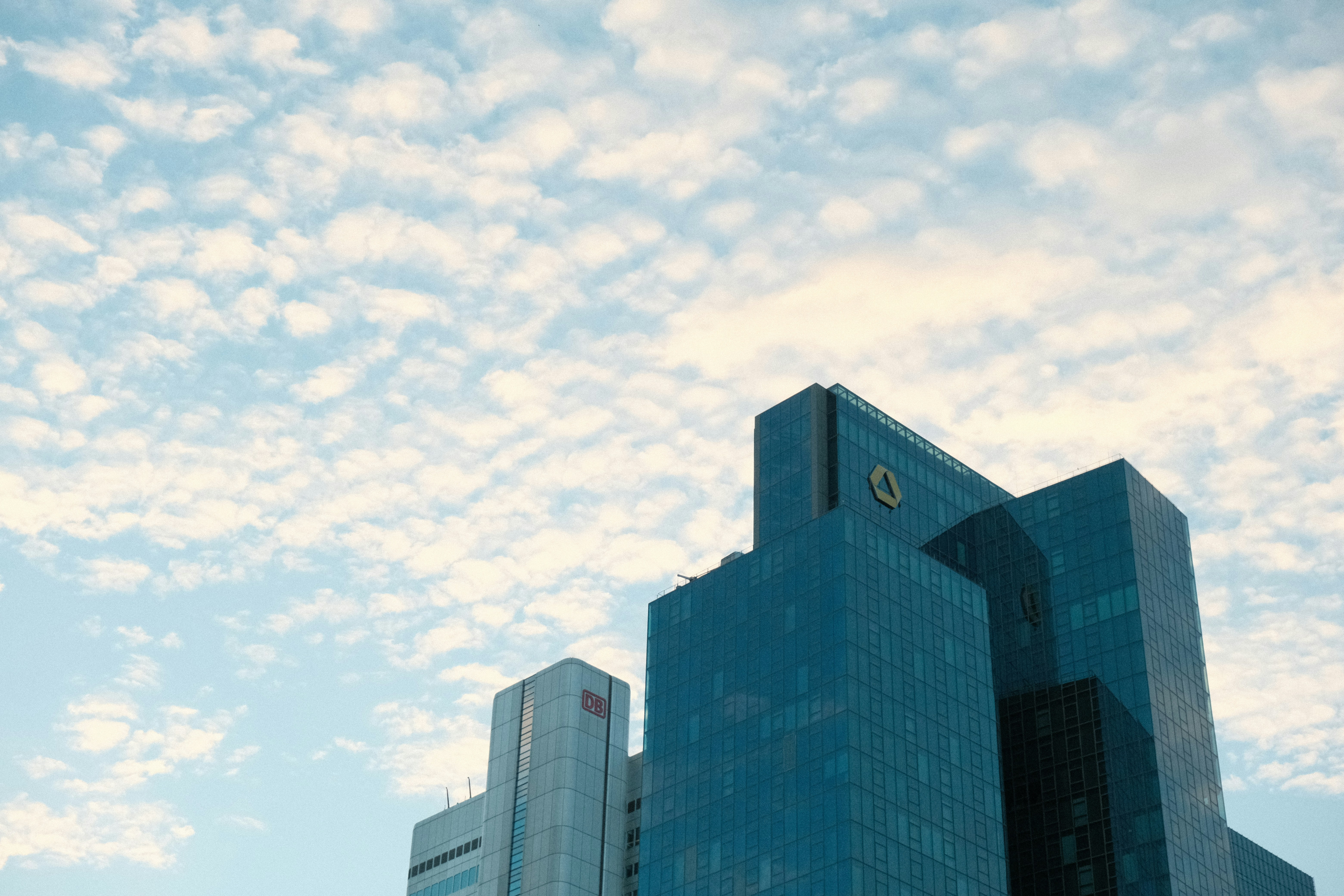 Azure Glass Giants Rise Against a Patchwork Sky