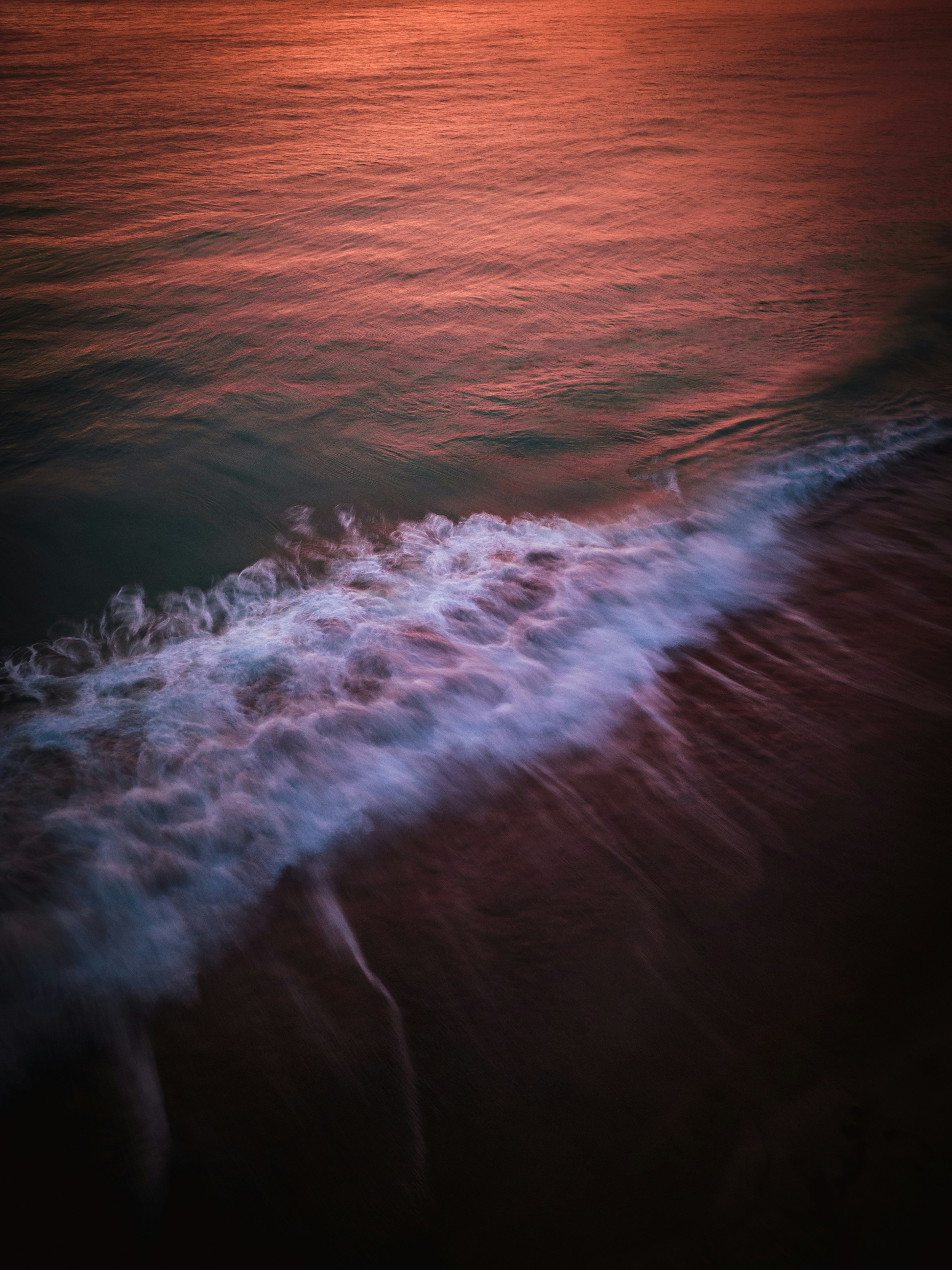 Crimson Wake Across Velvet Seas: A Dusk Long-Exposure Drift