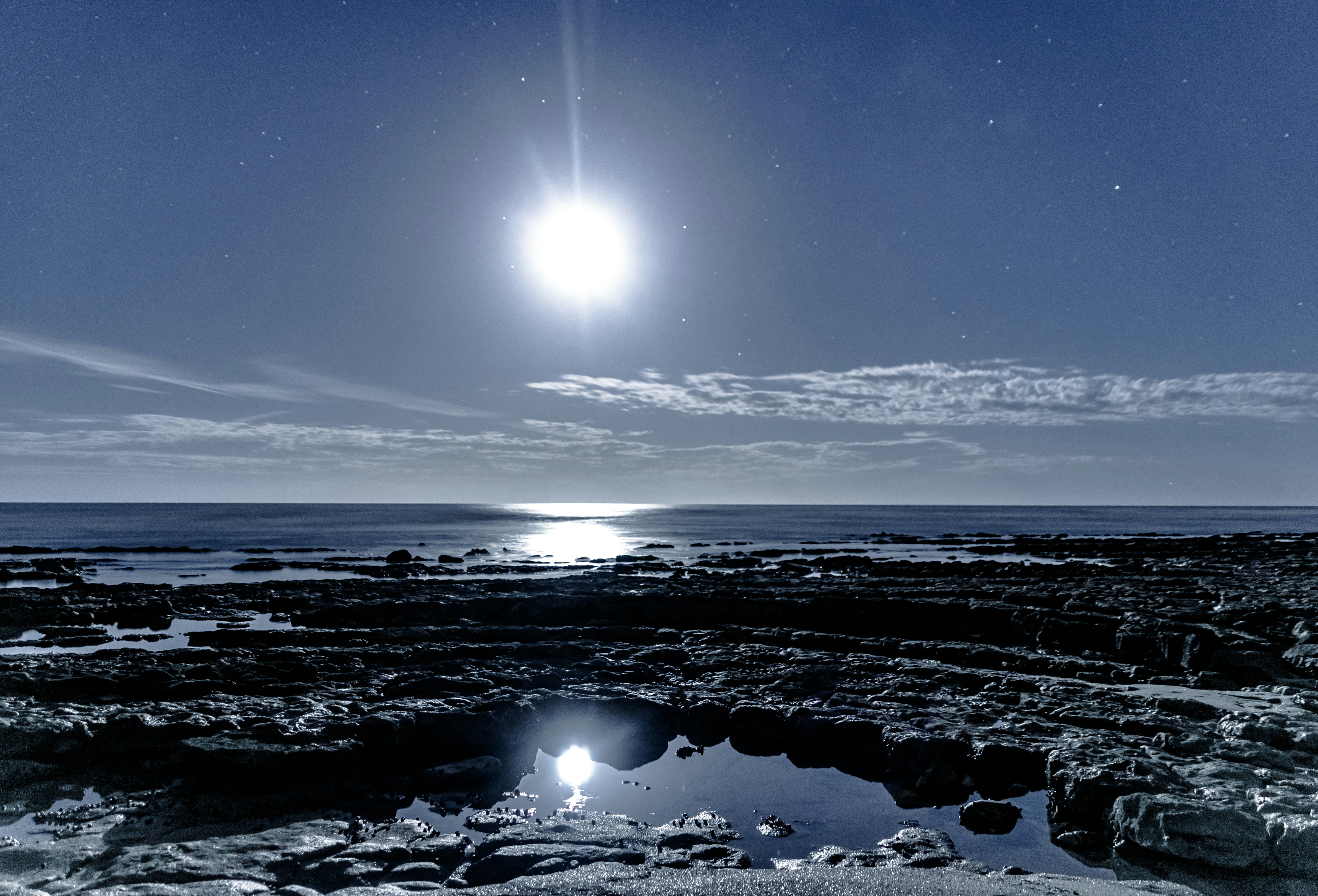 Moonlit Quiet: Lunar Reflections on a Rocky Tide Pool Shore