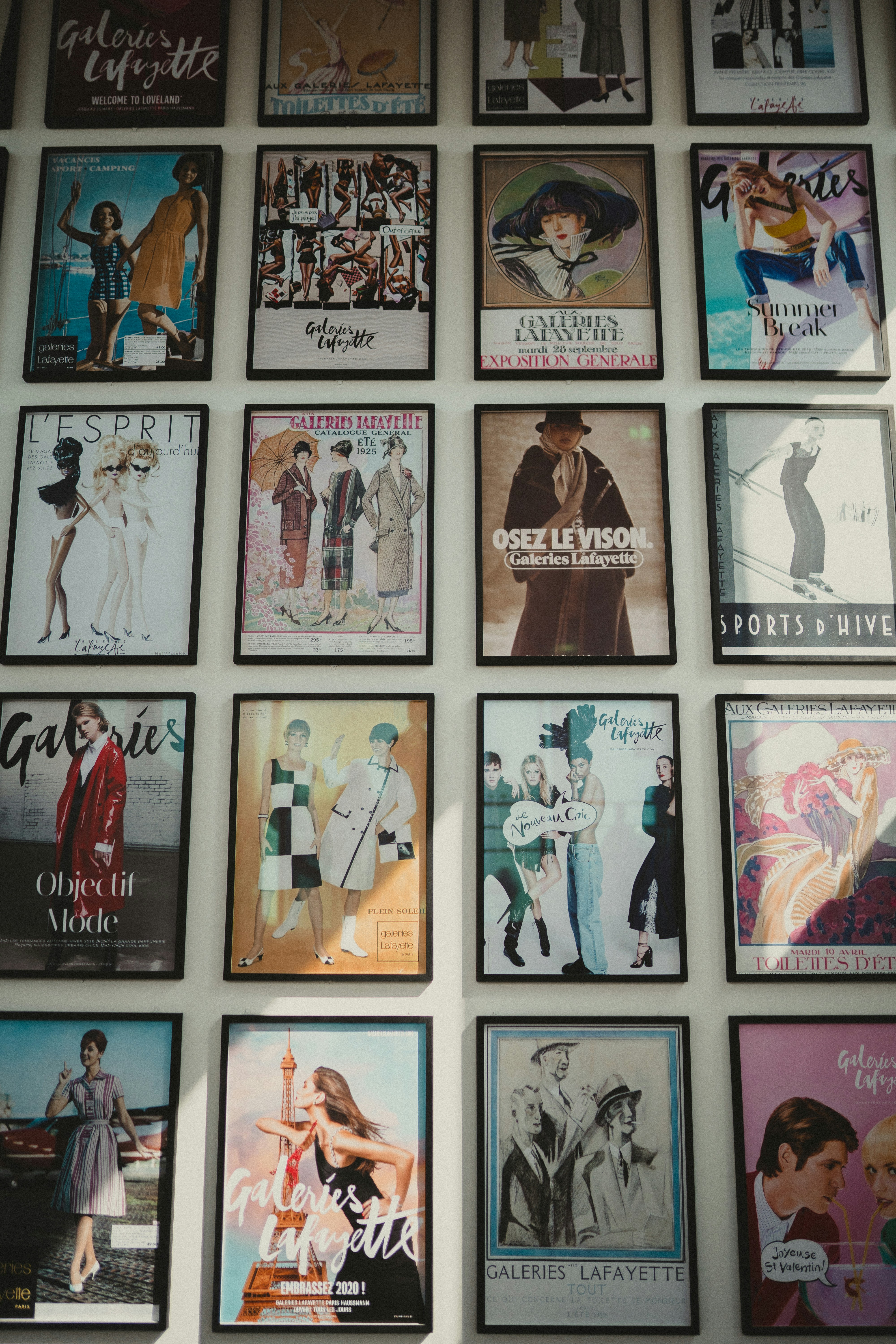 Grid of Vintage Fashion Posters Adorning a Parisian Gallery Wall
