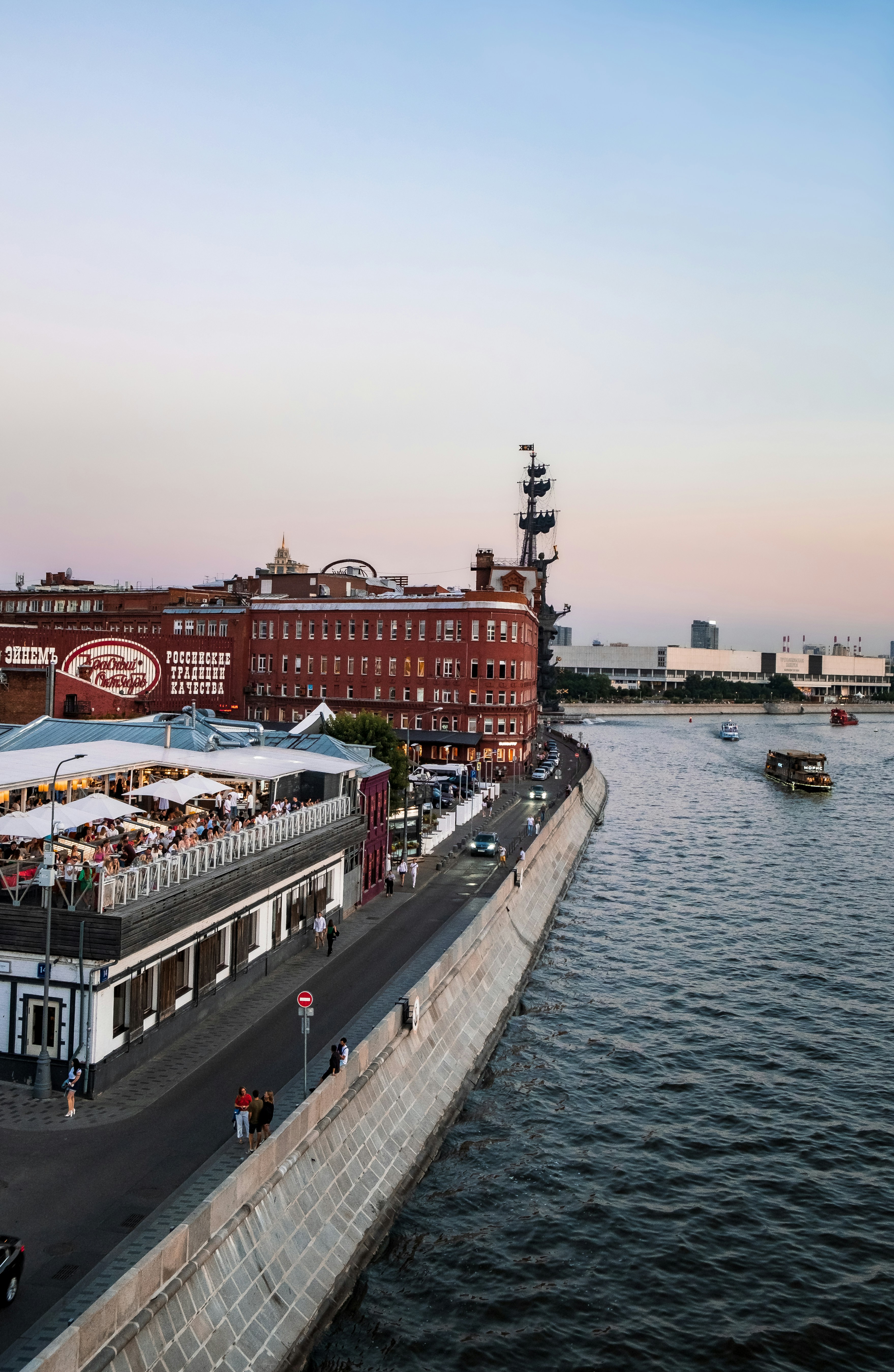 Harborfront Café Terrace Beside a Red Brick Landmark at Dusk