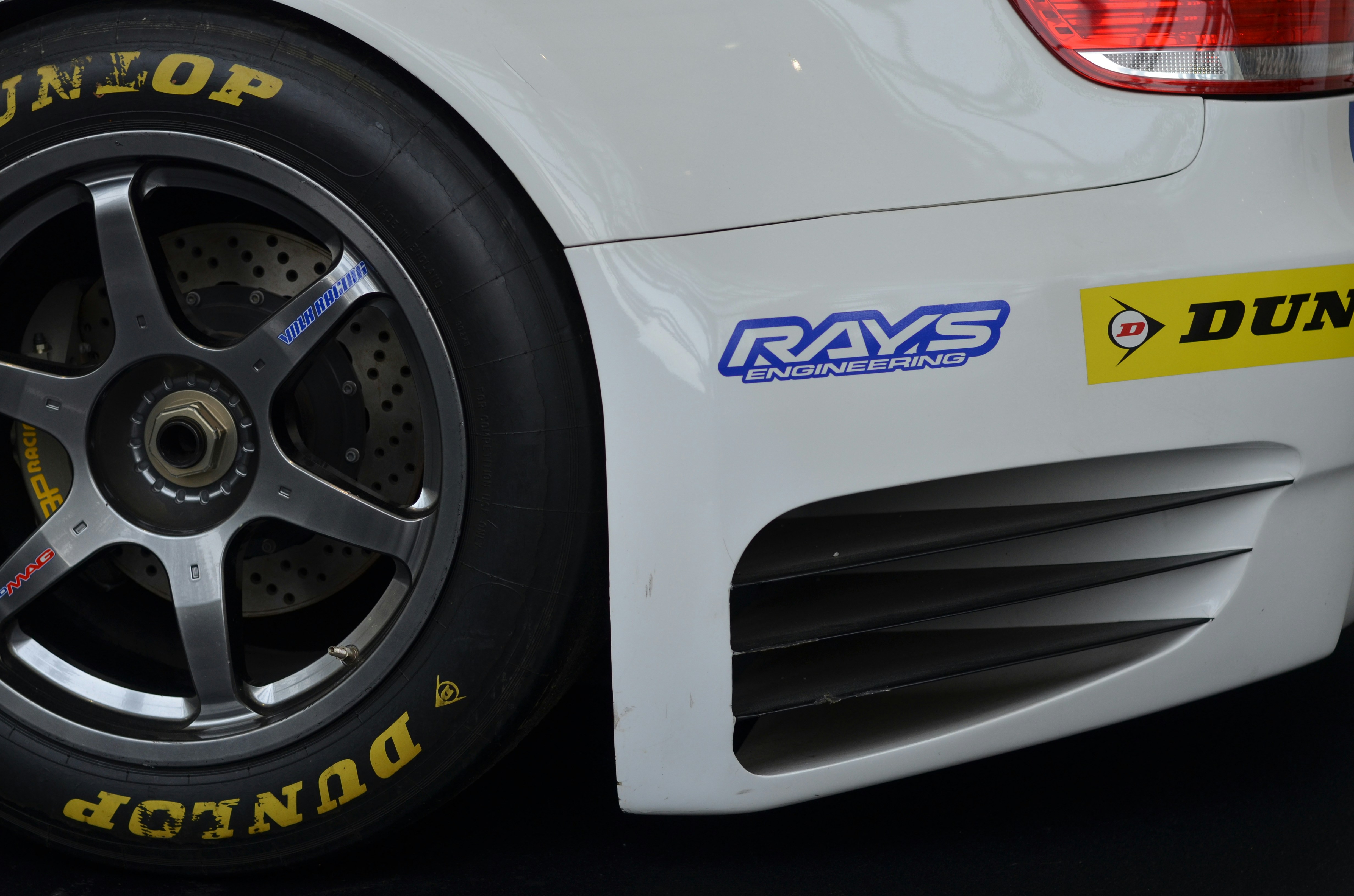 Rays Rim and Dunlop Script: Close-Up on a White Racing Car's Wheel