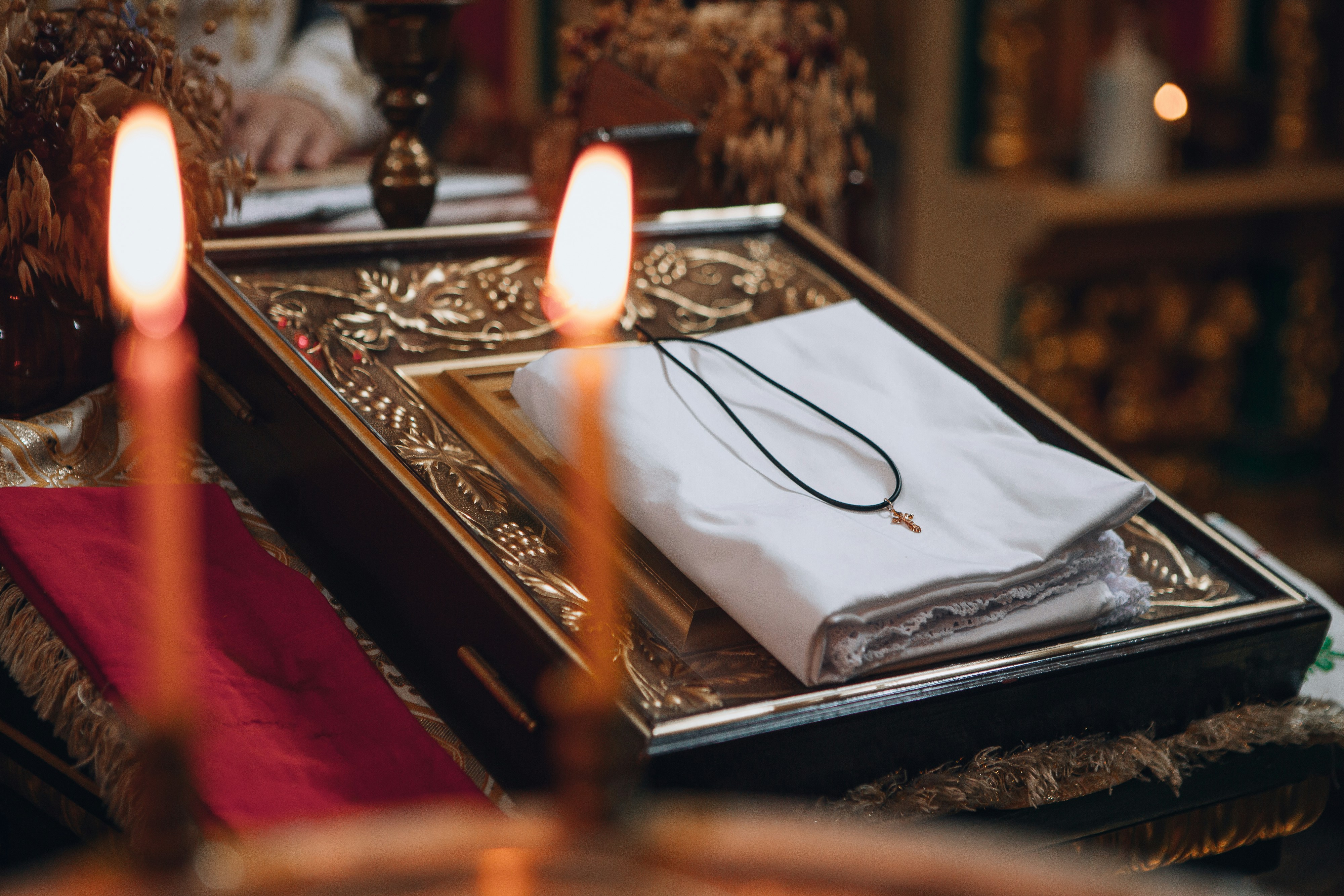 Candlelit reliquary with folded cloth resting on ornate altar