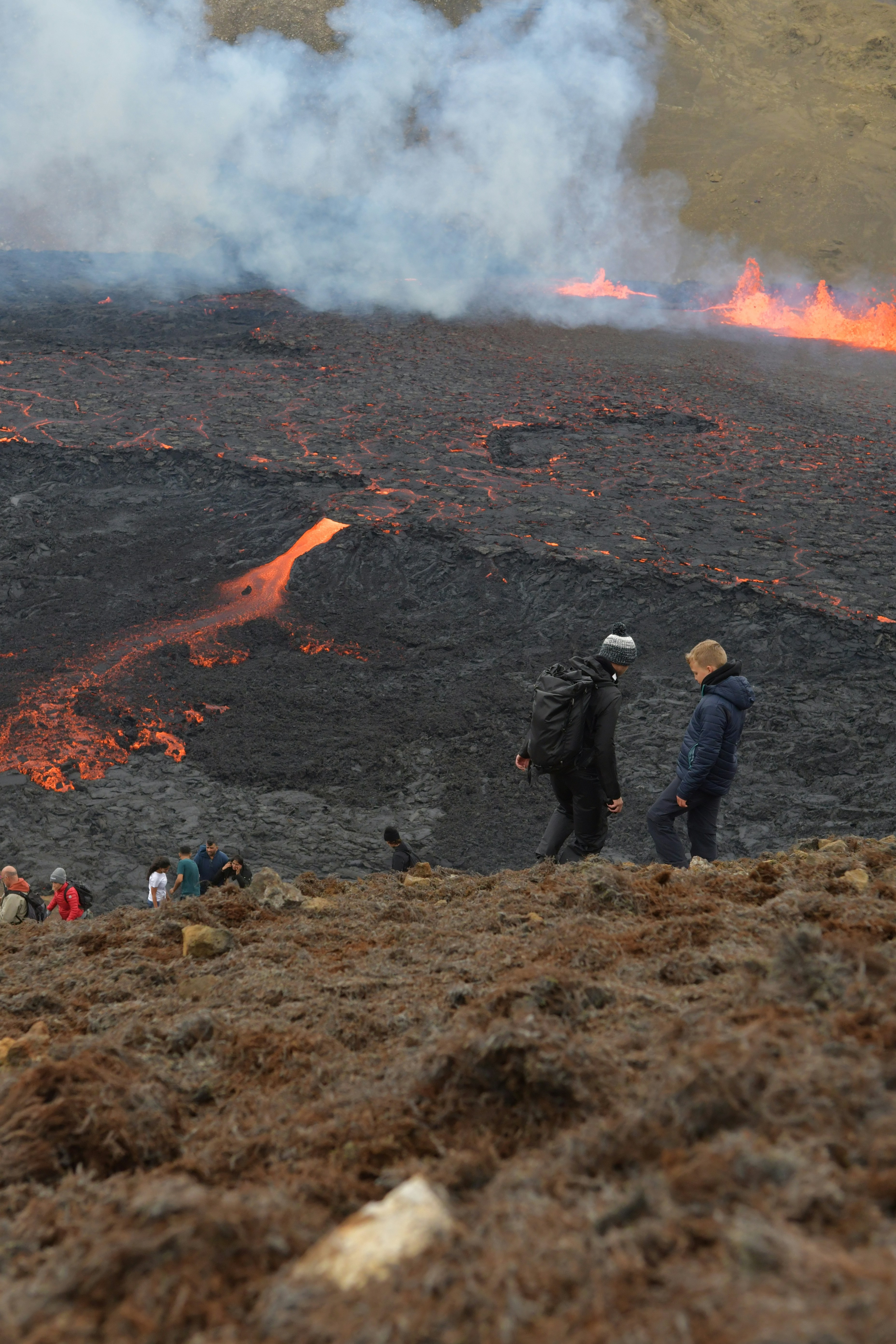 A group of people standing on a dirt hill with a large explosion photo ...