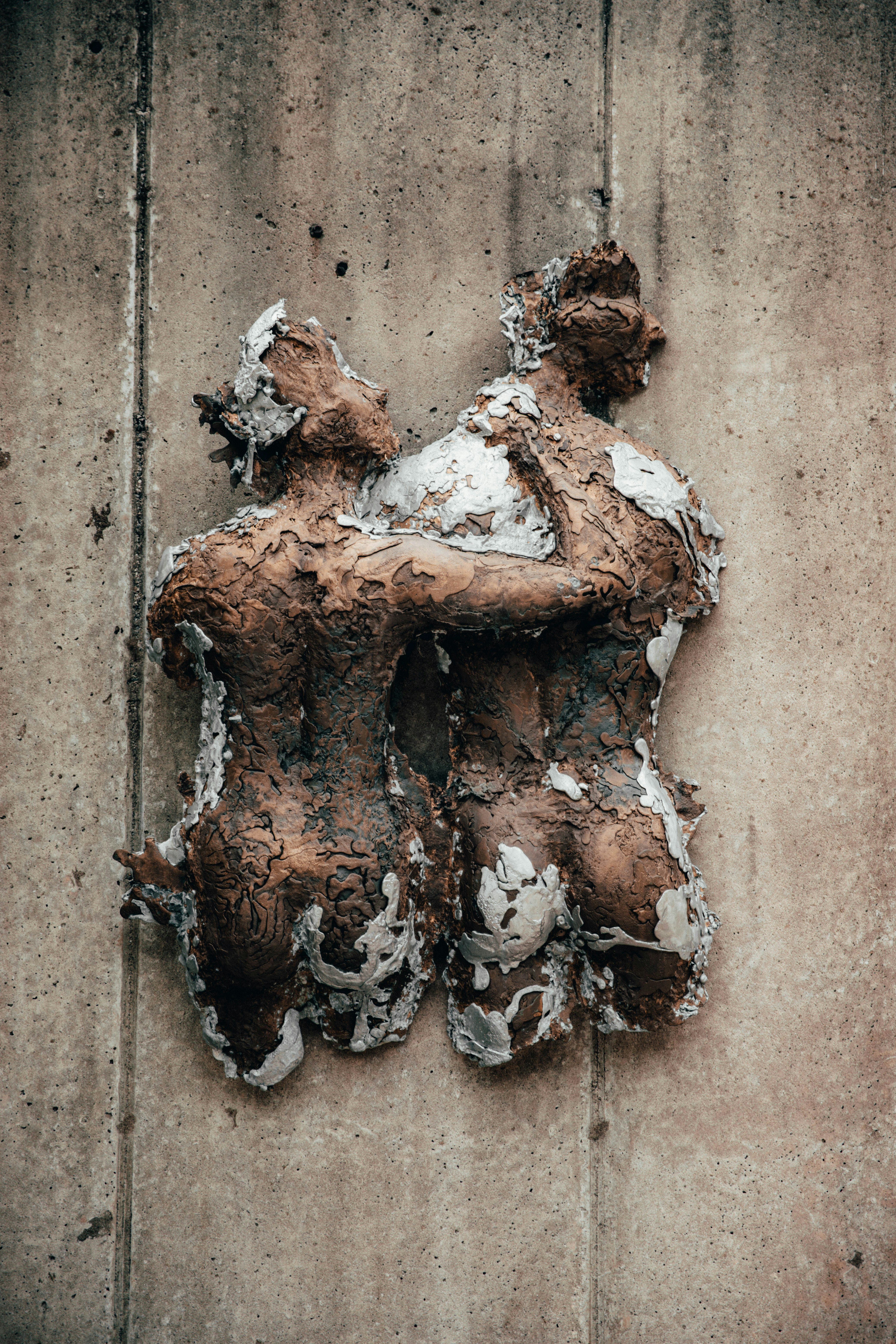 Embrace in Time: A Weathered Concrete Silhouette Formed by Peeling Paint