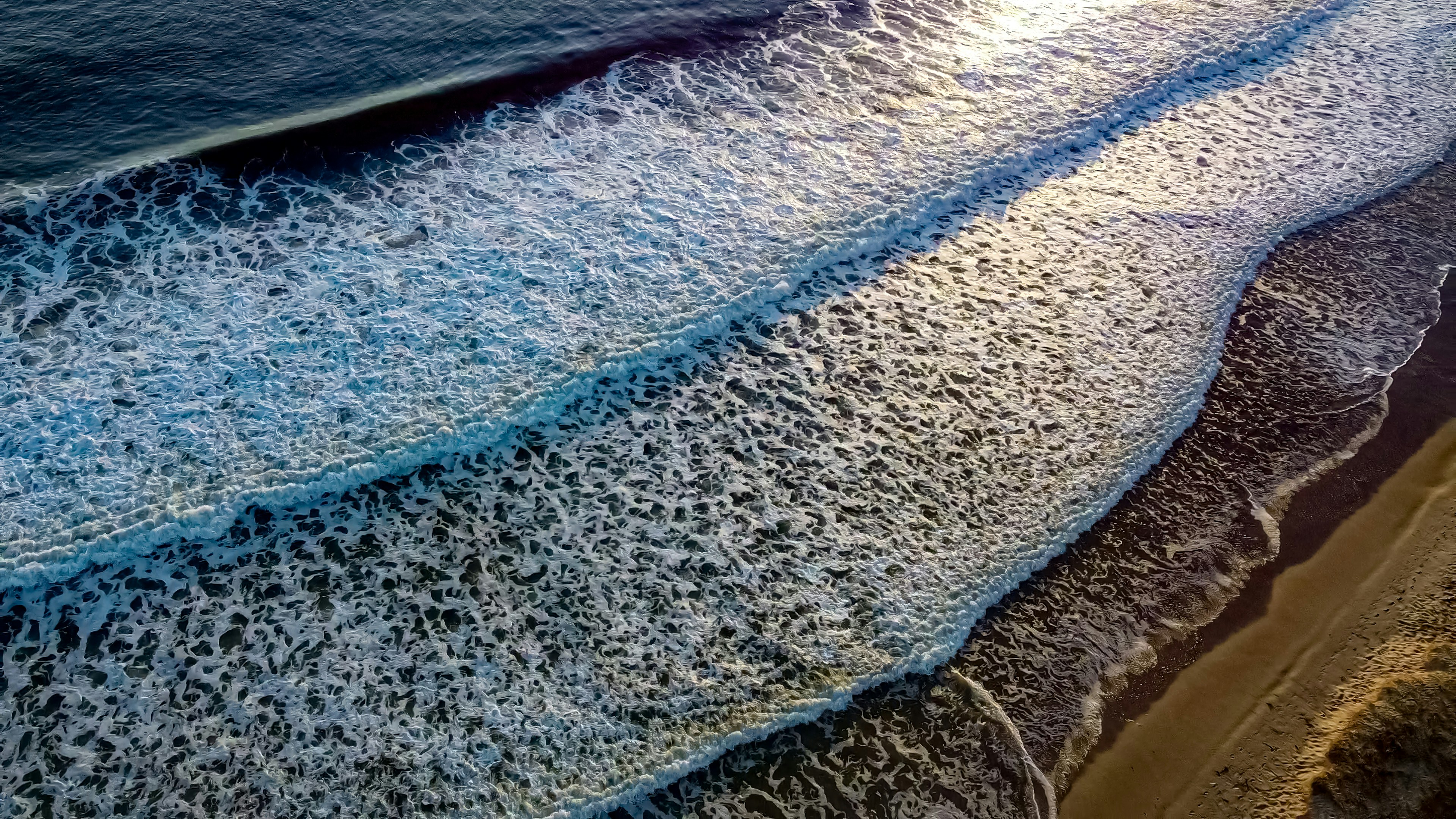 A beach with sand and water photo – Free Sunrise Image on Unsplash