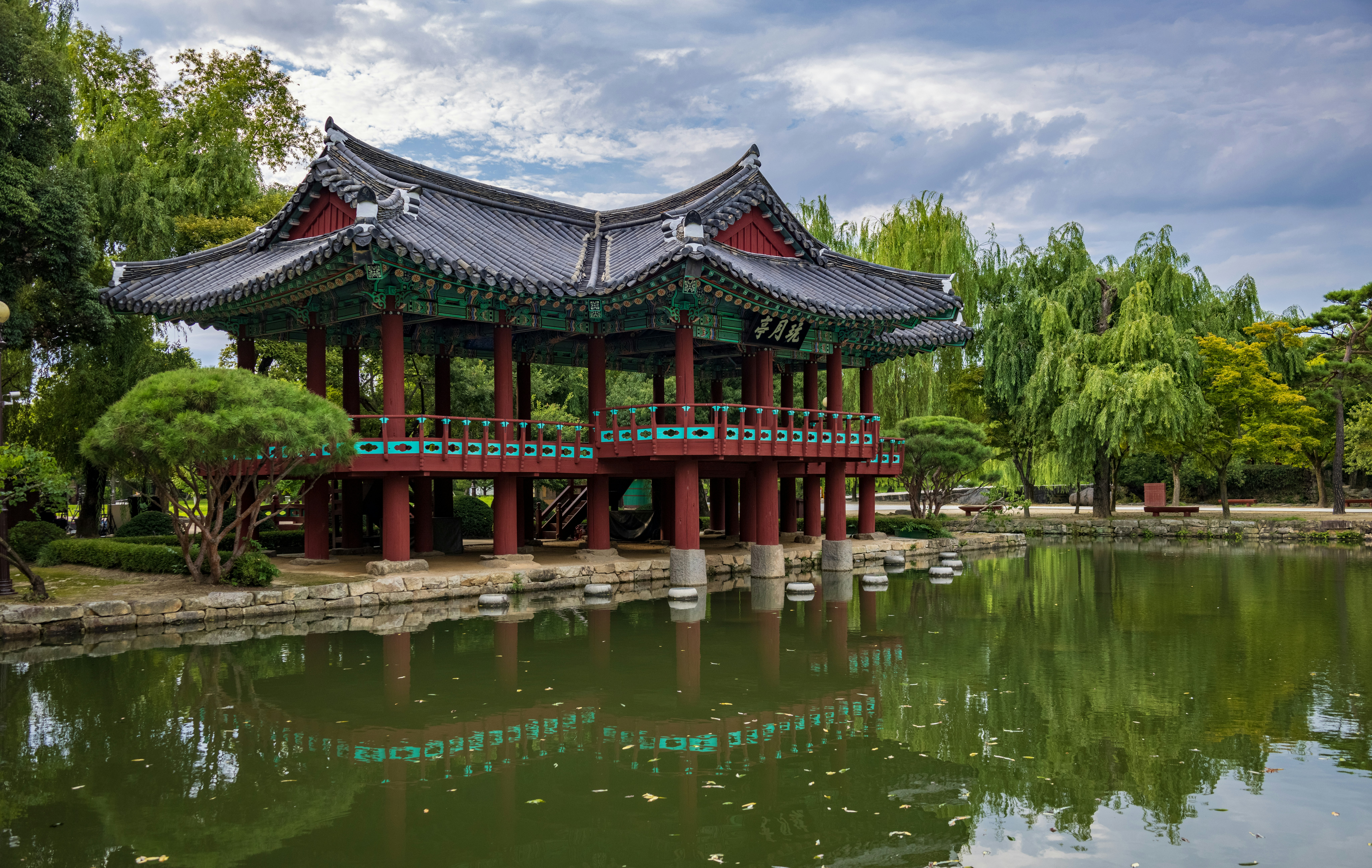 Foto Un edificio con un techo rojo rodeado de agua – Imagen Corea del ...