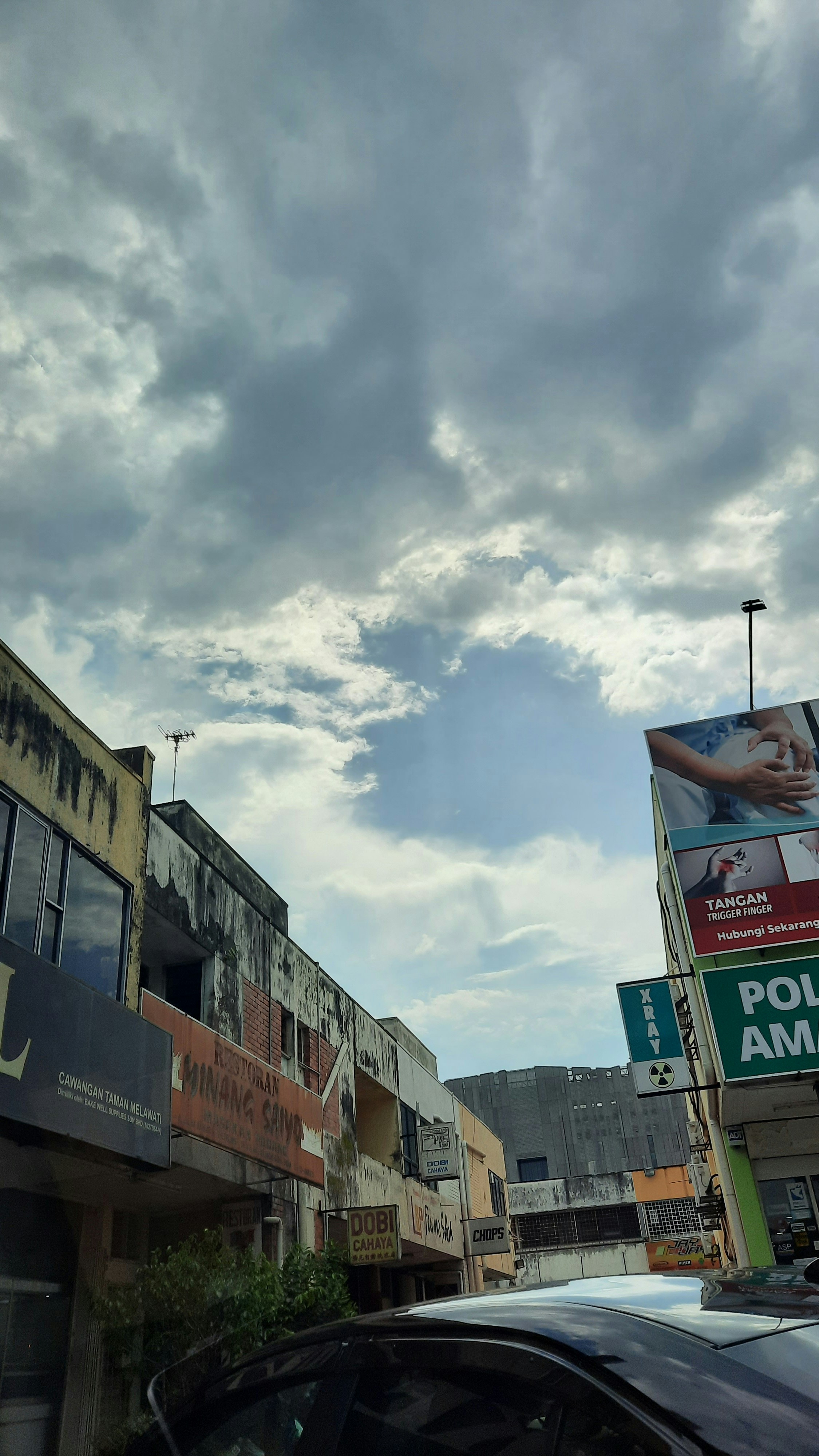 a street with buildings and a cloudy sky