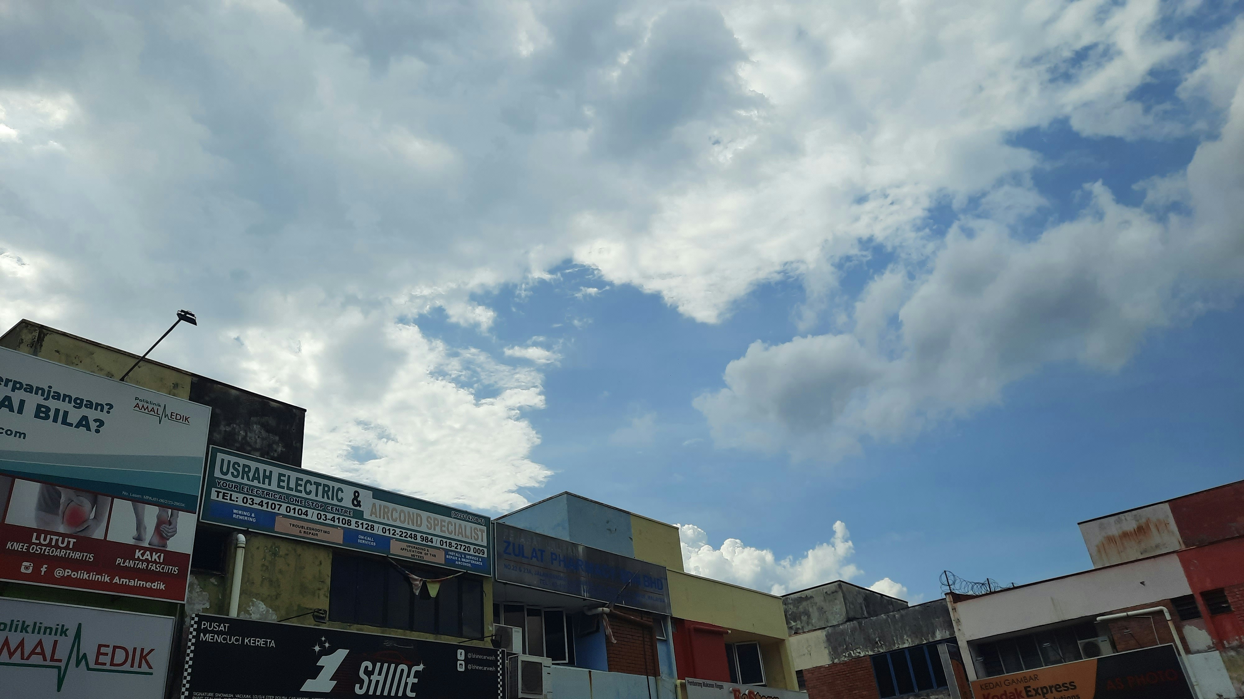 Neon Trim in a Row: Colorful Shopfronts Under an Expansive Sky