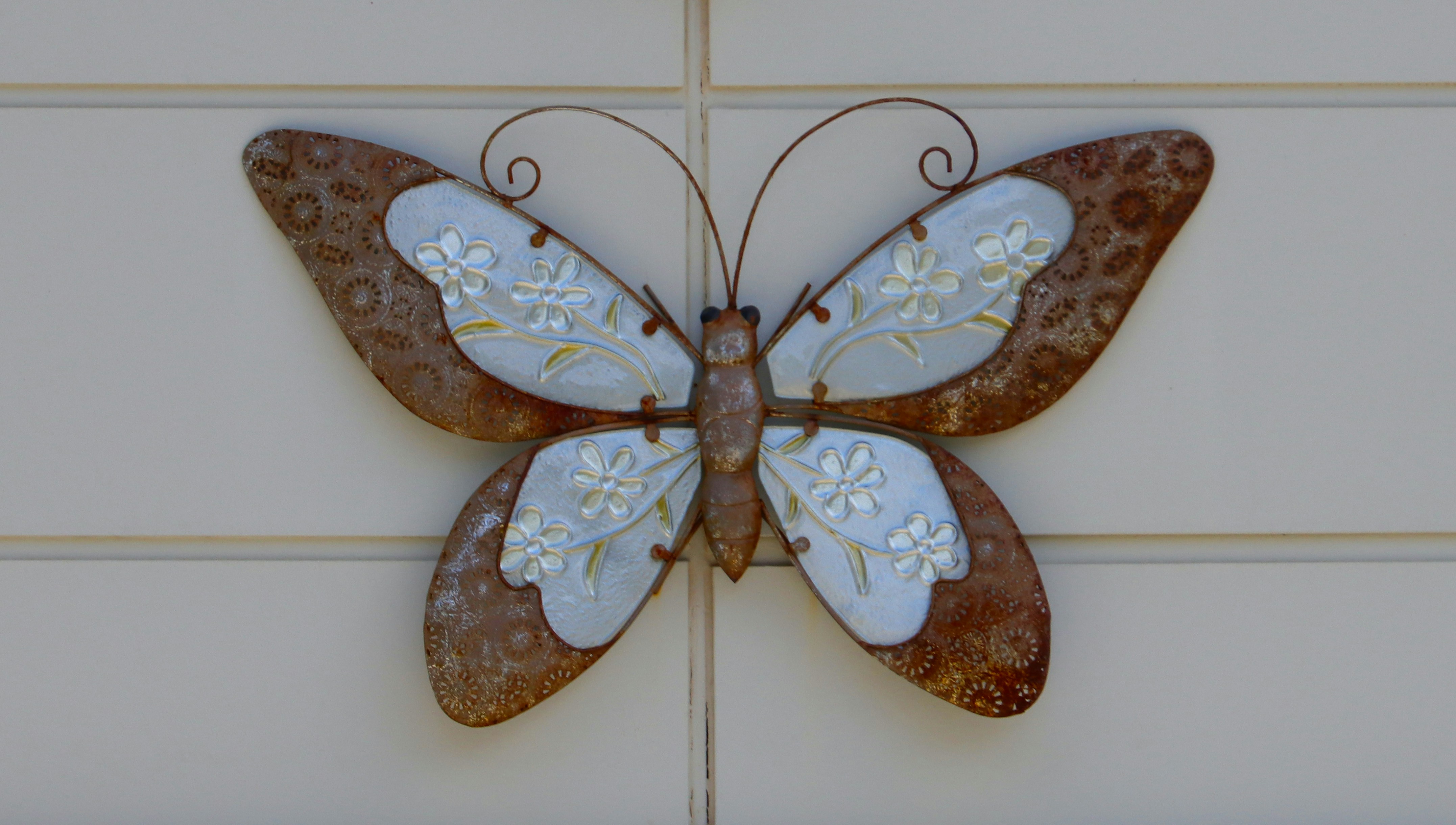 Rust and Sky Wings: A Metal Butterfly Adorns Ceramic Tiles