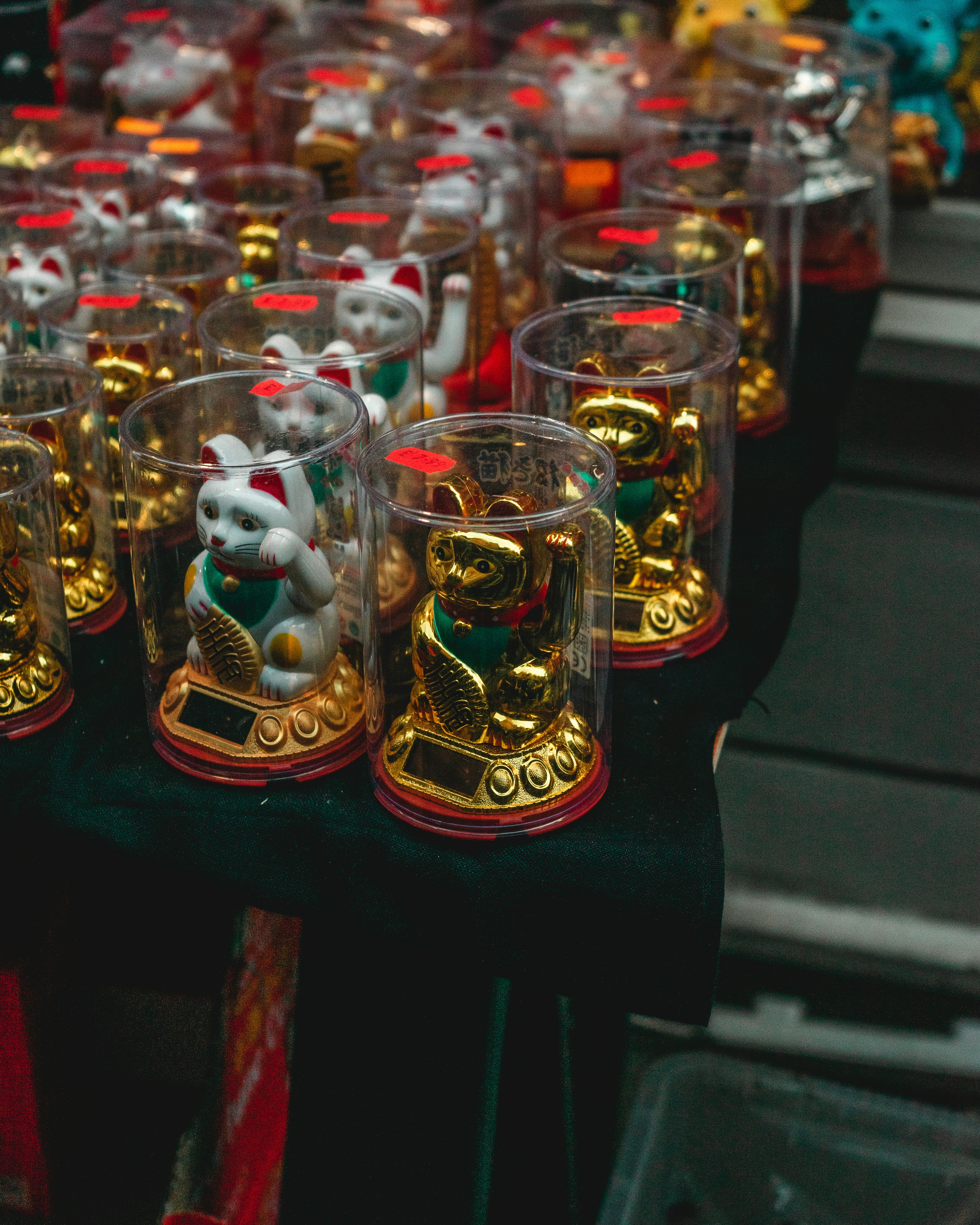 Glass-Domed Maneki-Neko Parade on a Market Table