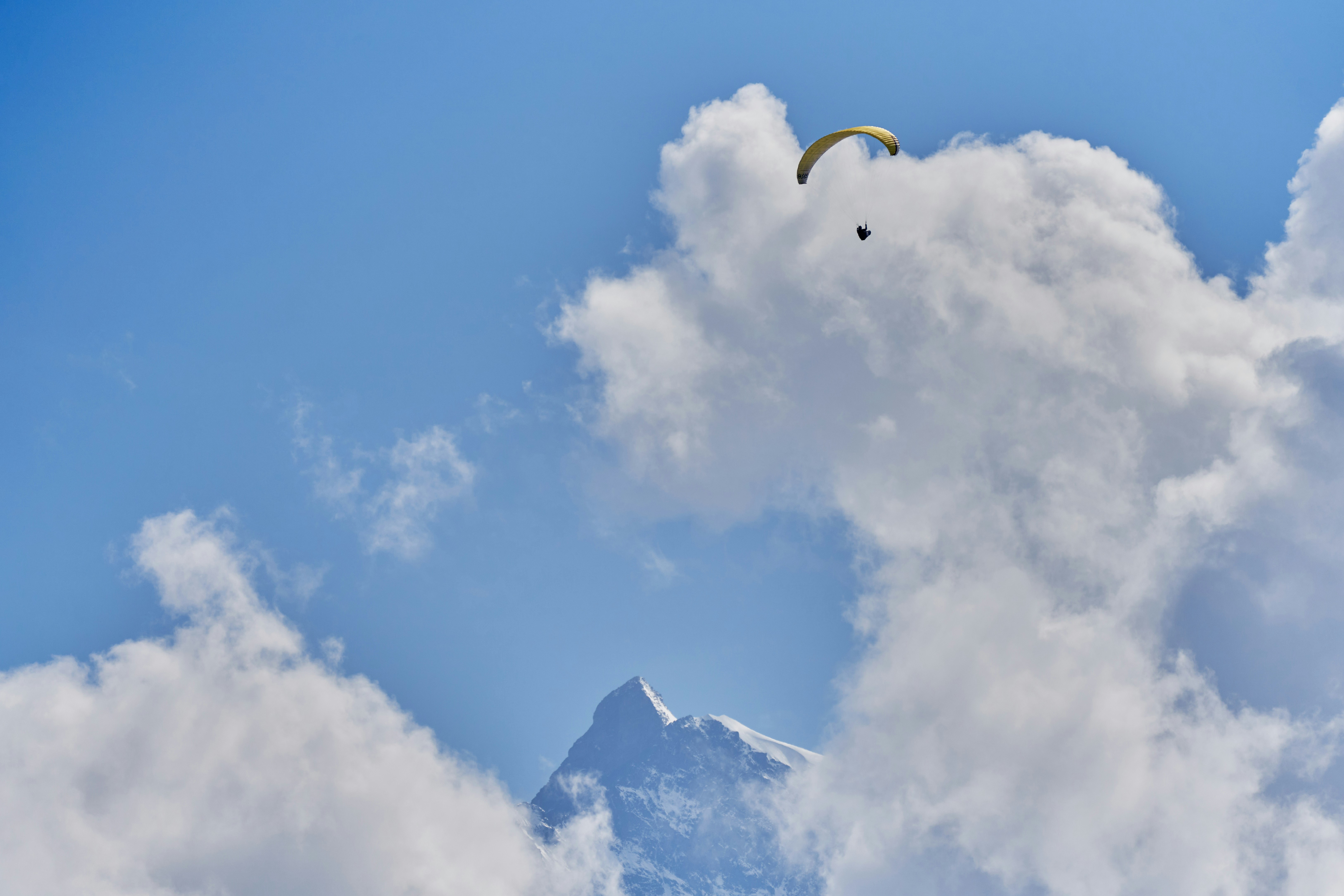 Paraglider Above Snow-Crowned Peaks