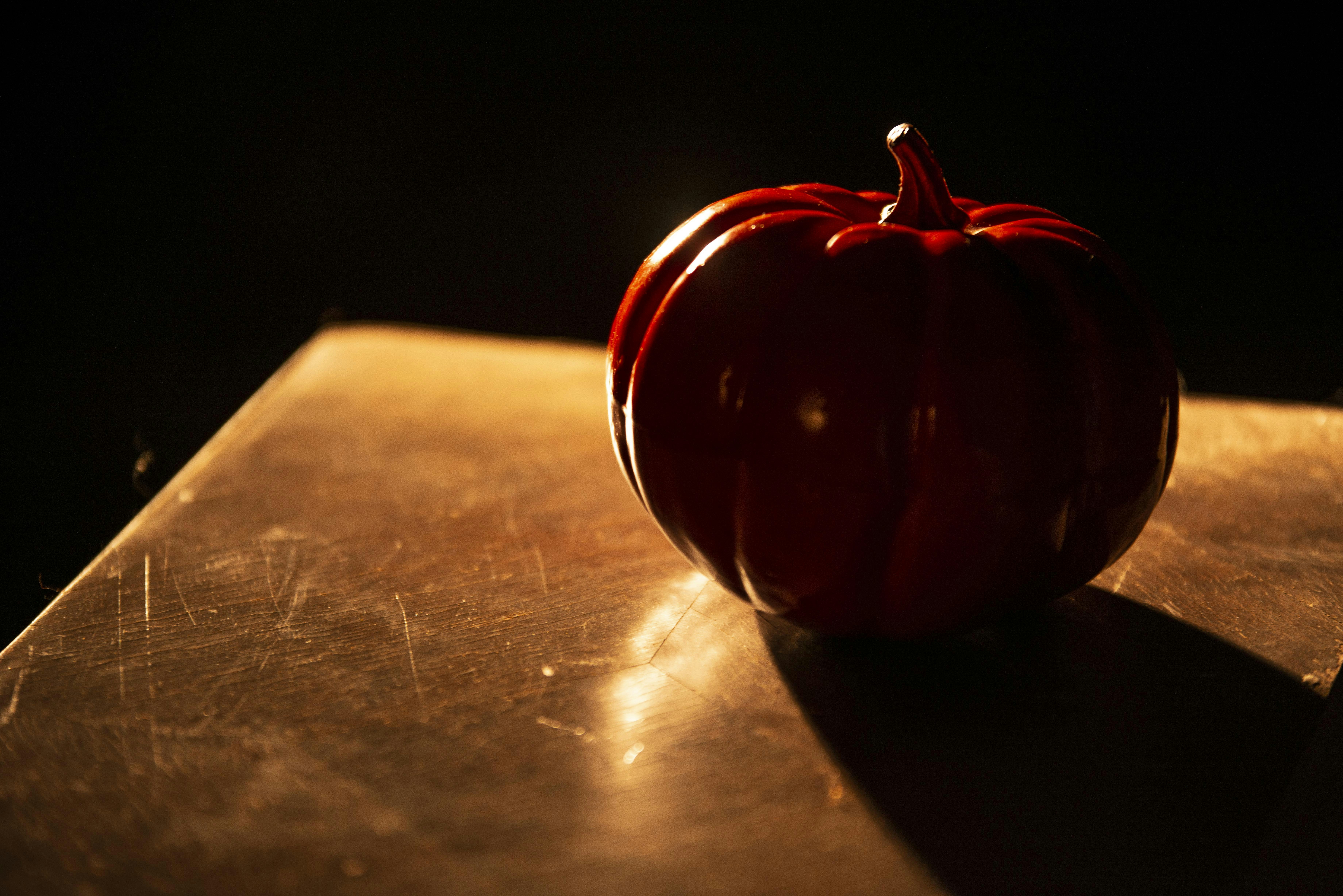 Scarlet Pepper under a Quiet Spotlight on Weathered Wood