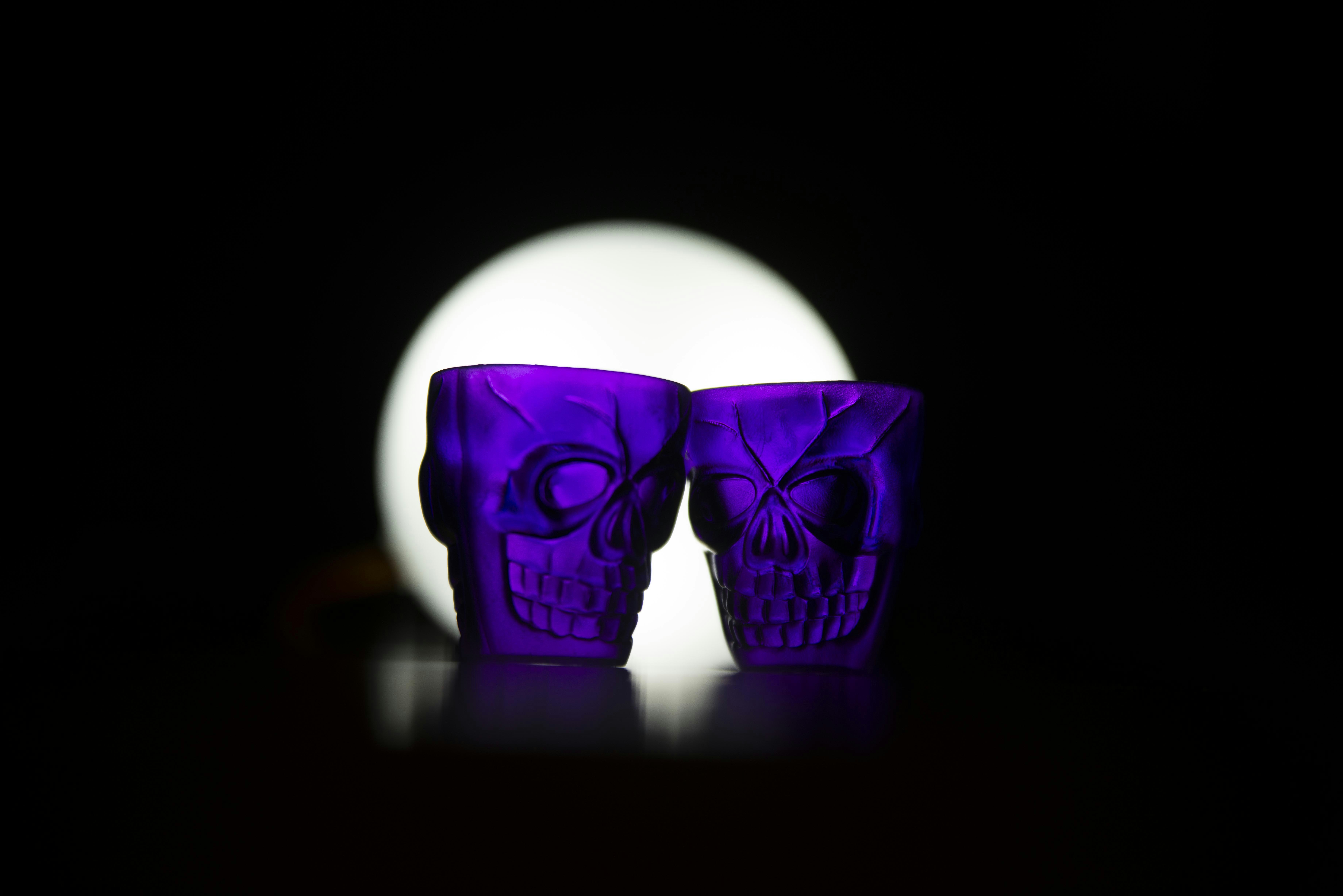 Backlit Purple Skull Goblets: Quiet Glow on a Reflective Surface