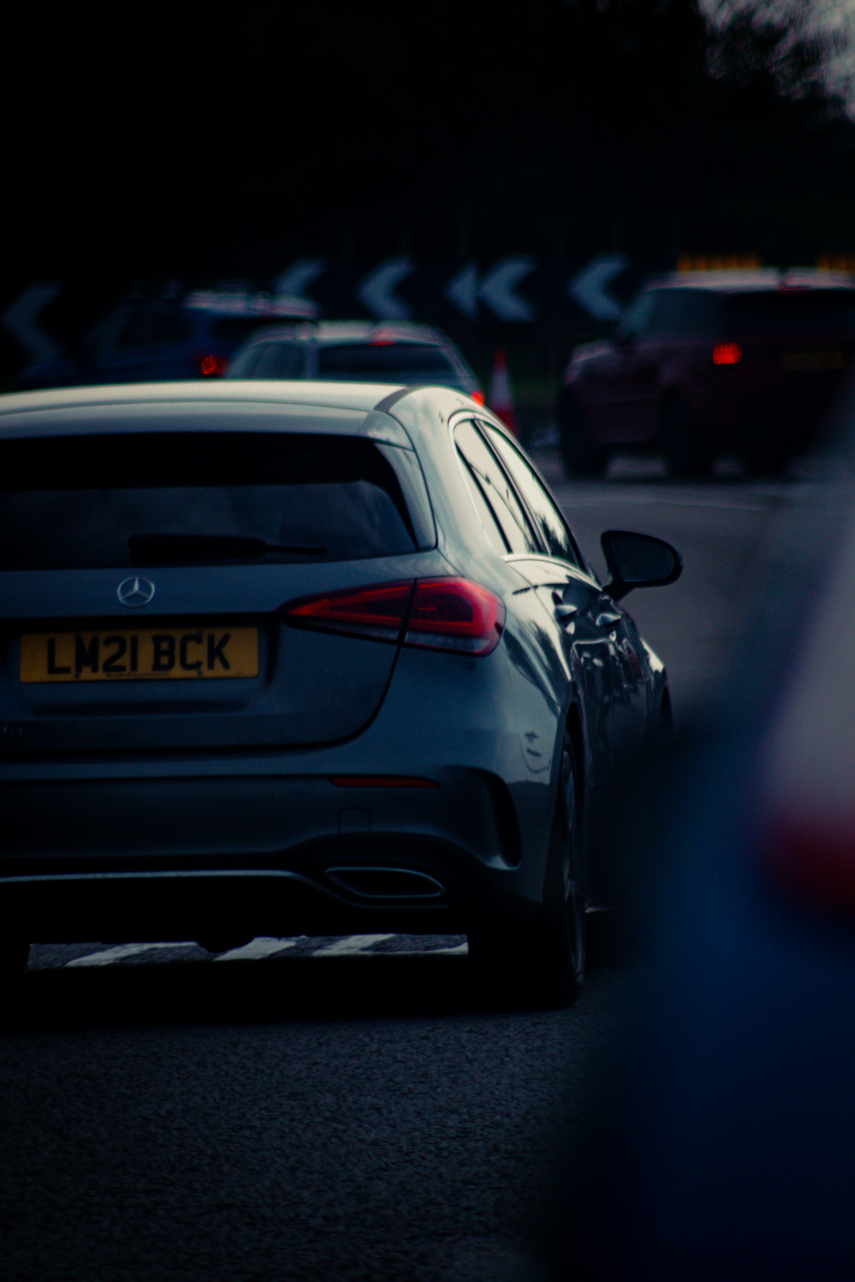 Tail Lights in Traffic: A Silver Mercedes Navigates Evening Congestion