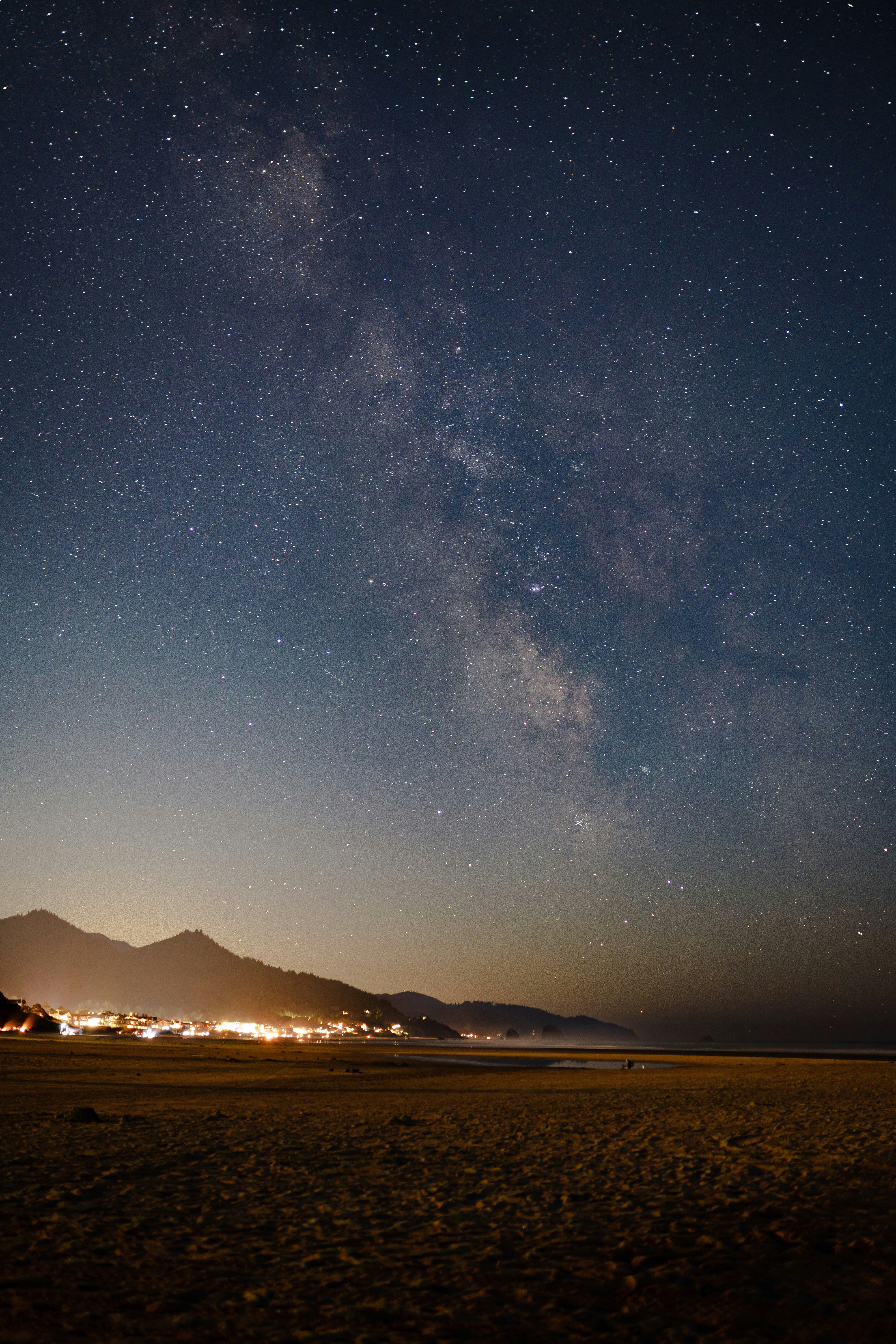 a landscape with mountains and stars in the sky