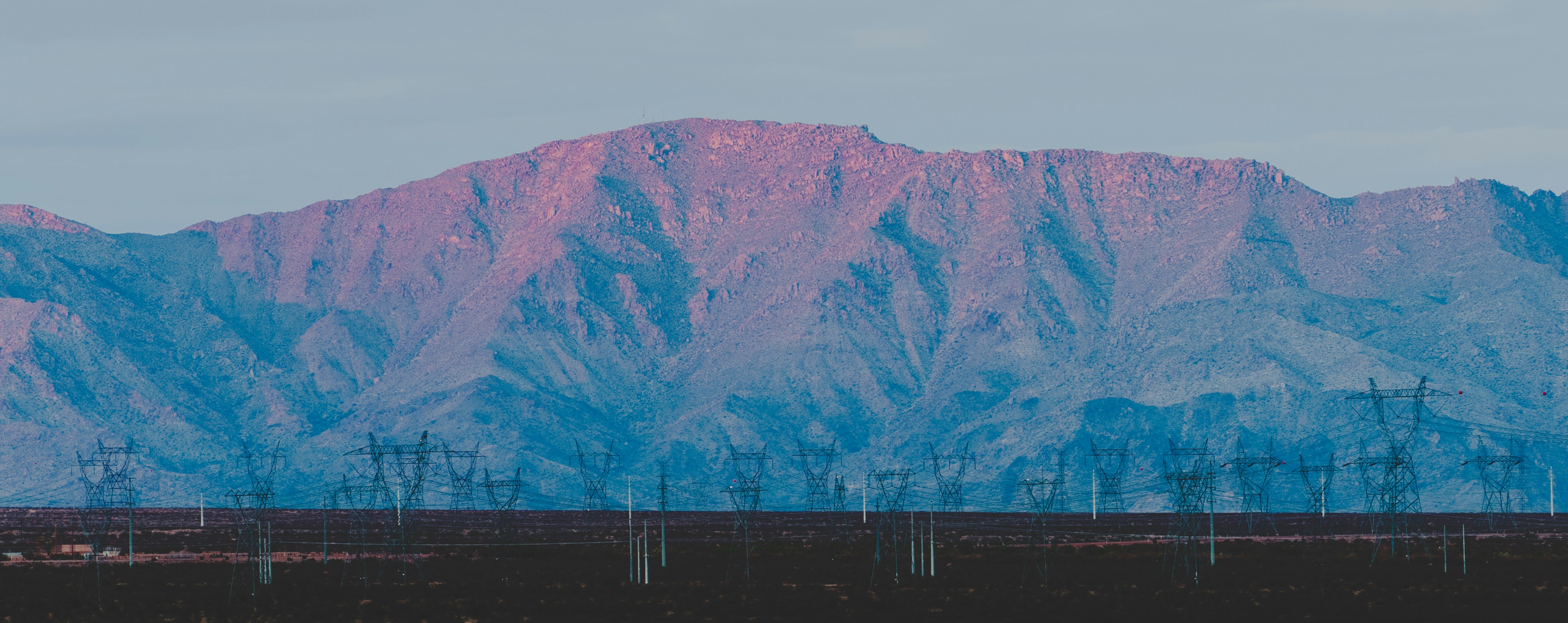 Alpenglow Ridge: Rosy Crest Above a Desert Powerline Plain