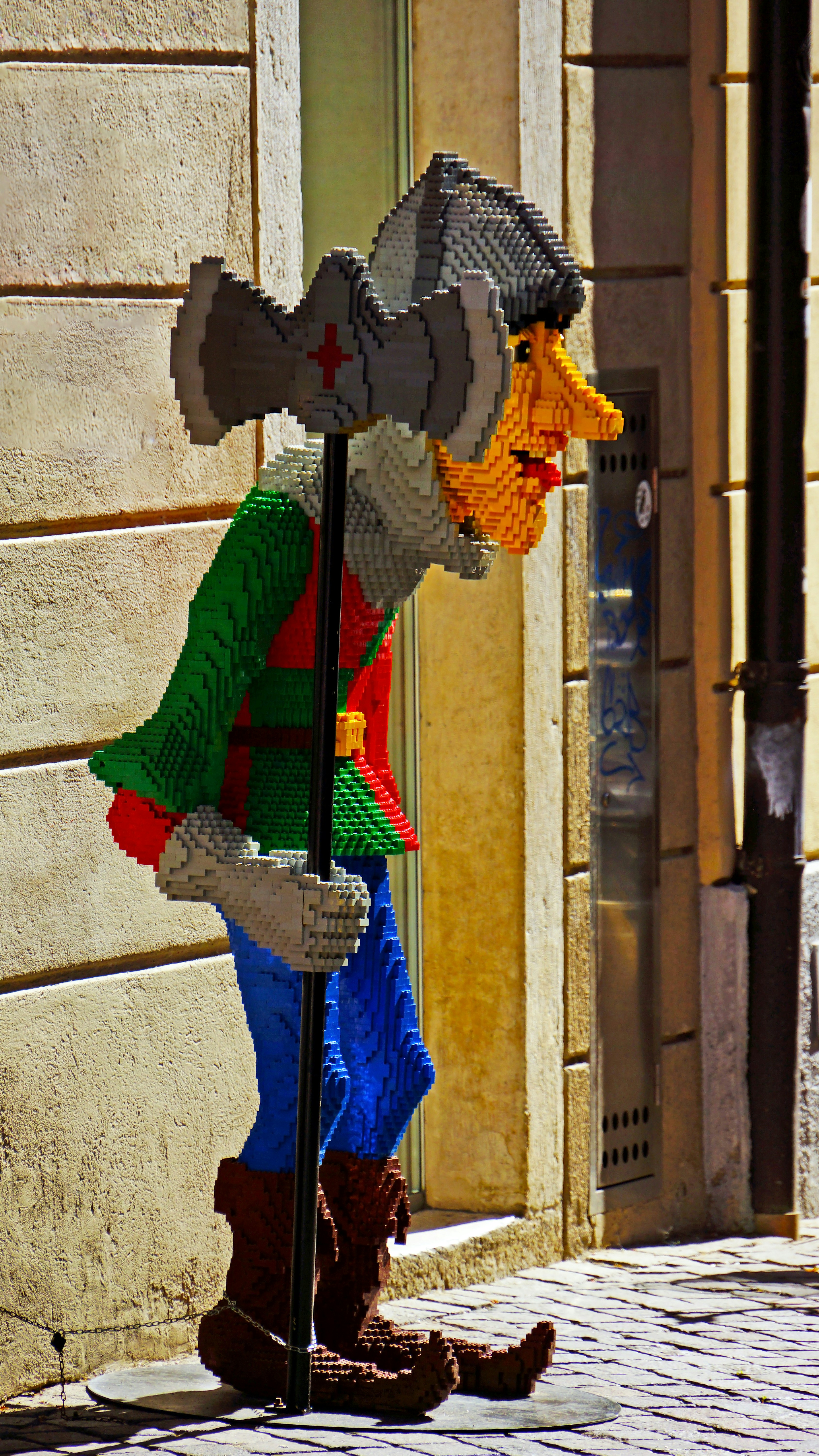 Brick Wrangler by the Doorway: A LEGO Cowboy Sculpture in Sunlit Street