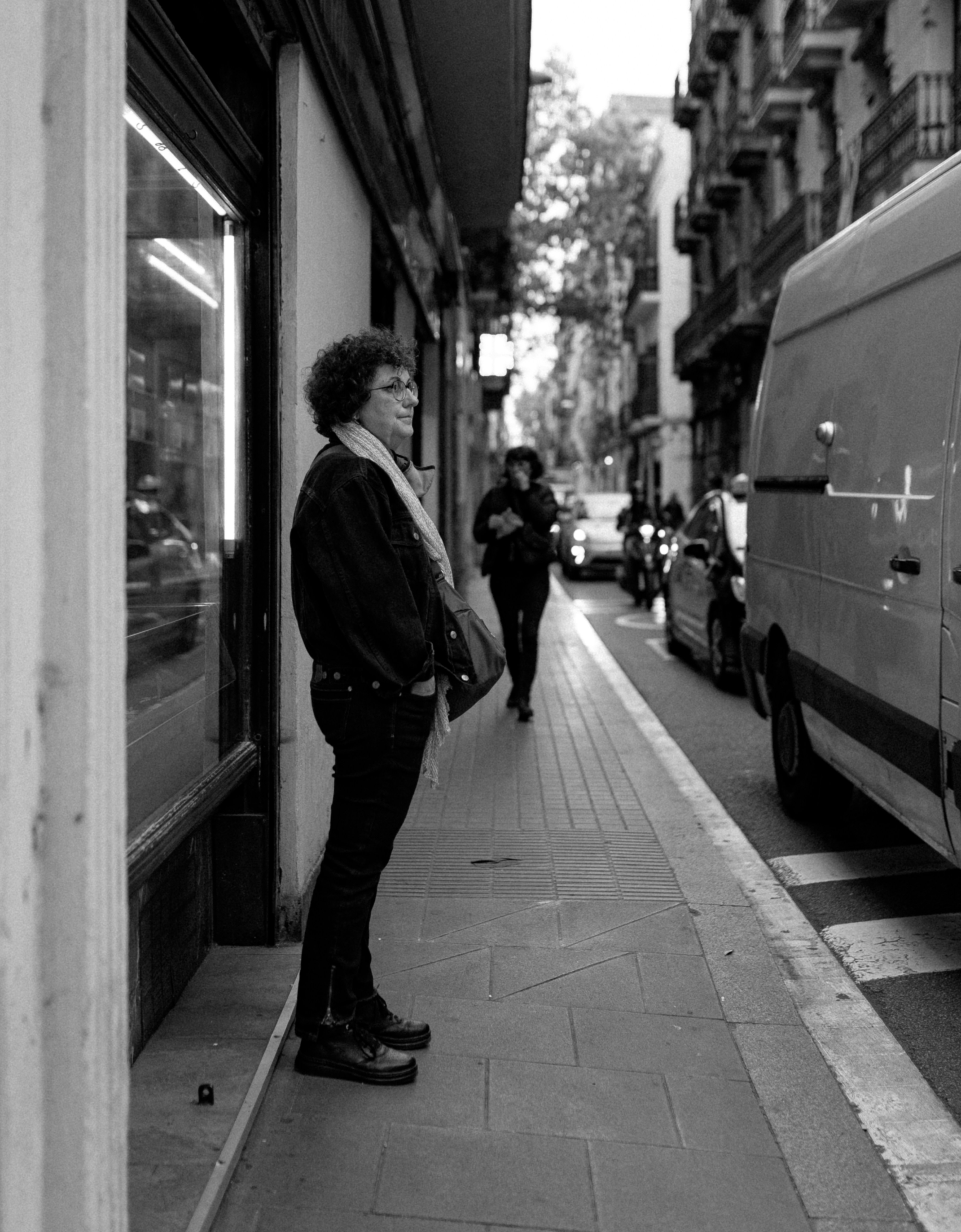 Monochrome Pause on a City Street: Storefront Portrait by the Van