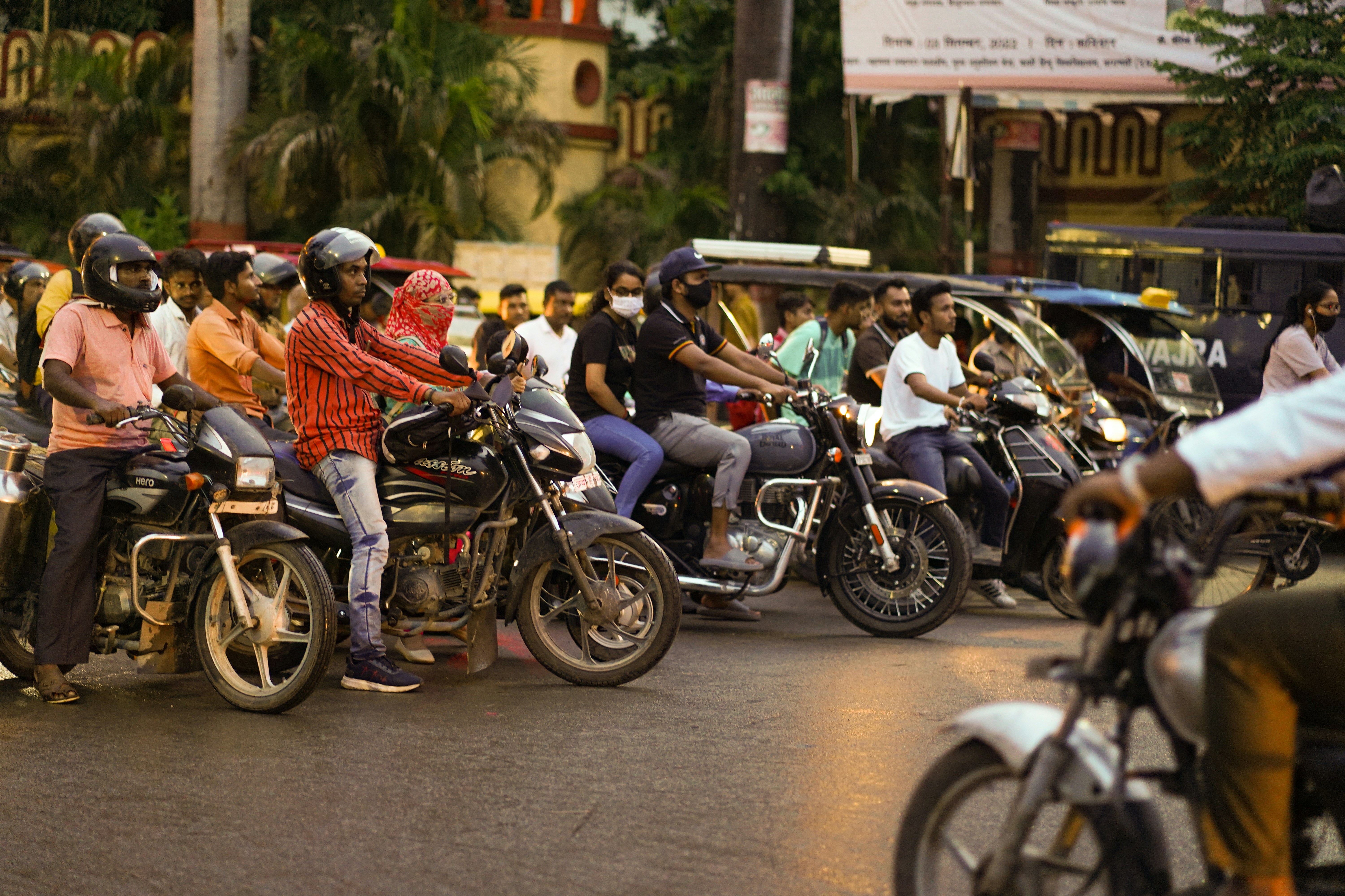 A group of people ride motorcycles down a busy street photo – Free ...